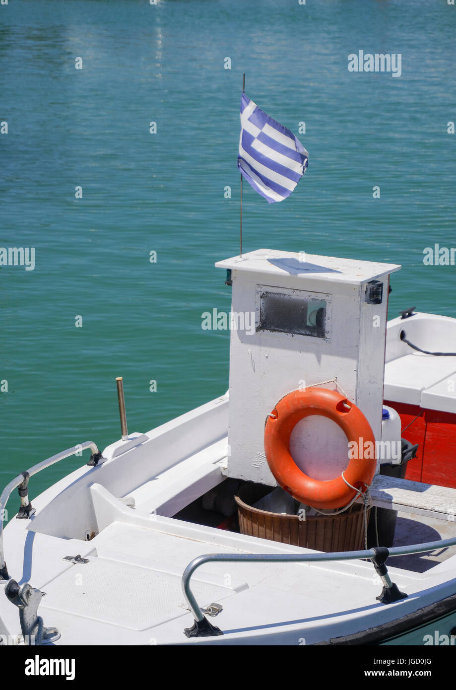 White boat with swim ring floating by the seafront at Greece on a sunny ...