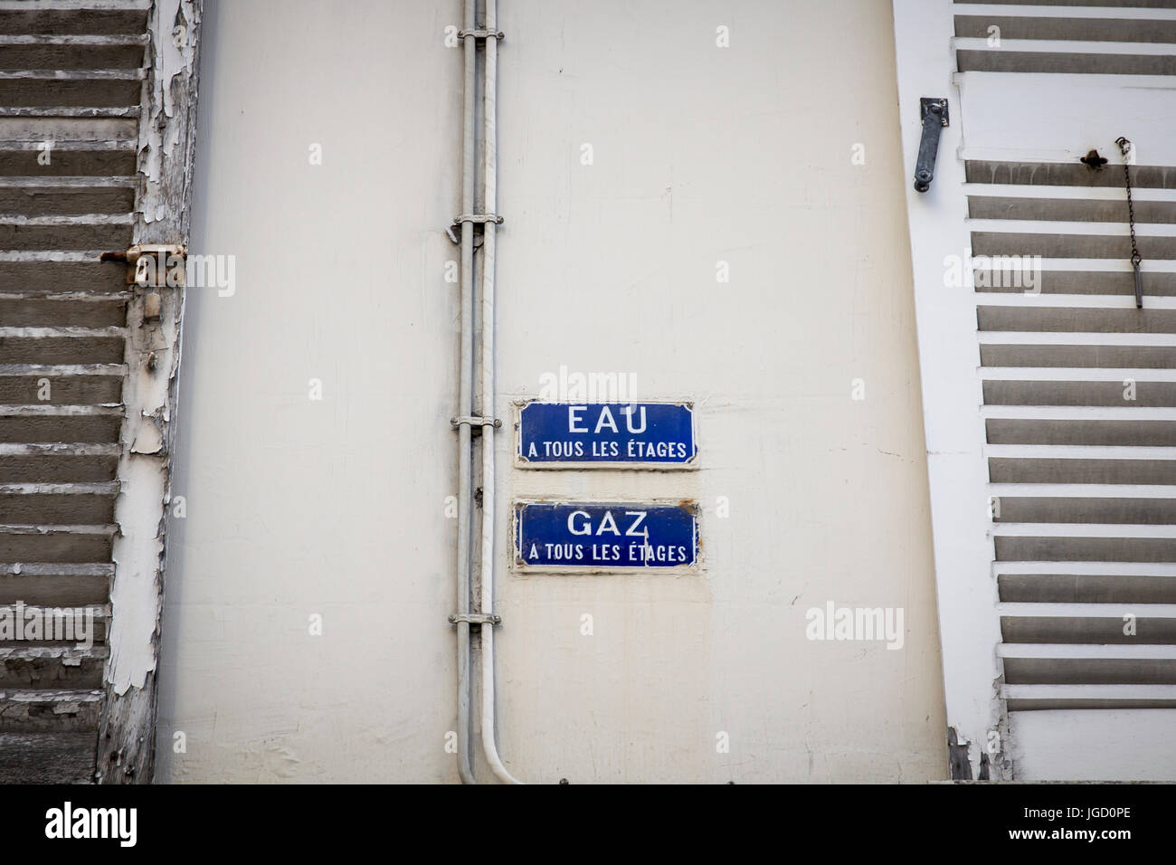 Old white front building in Paris, with outside water and gas pipes ...