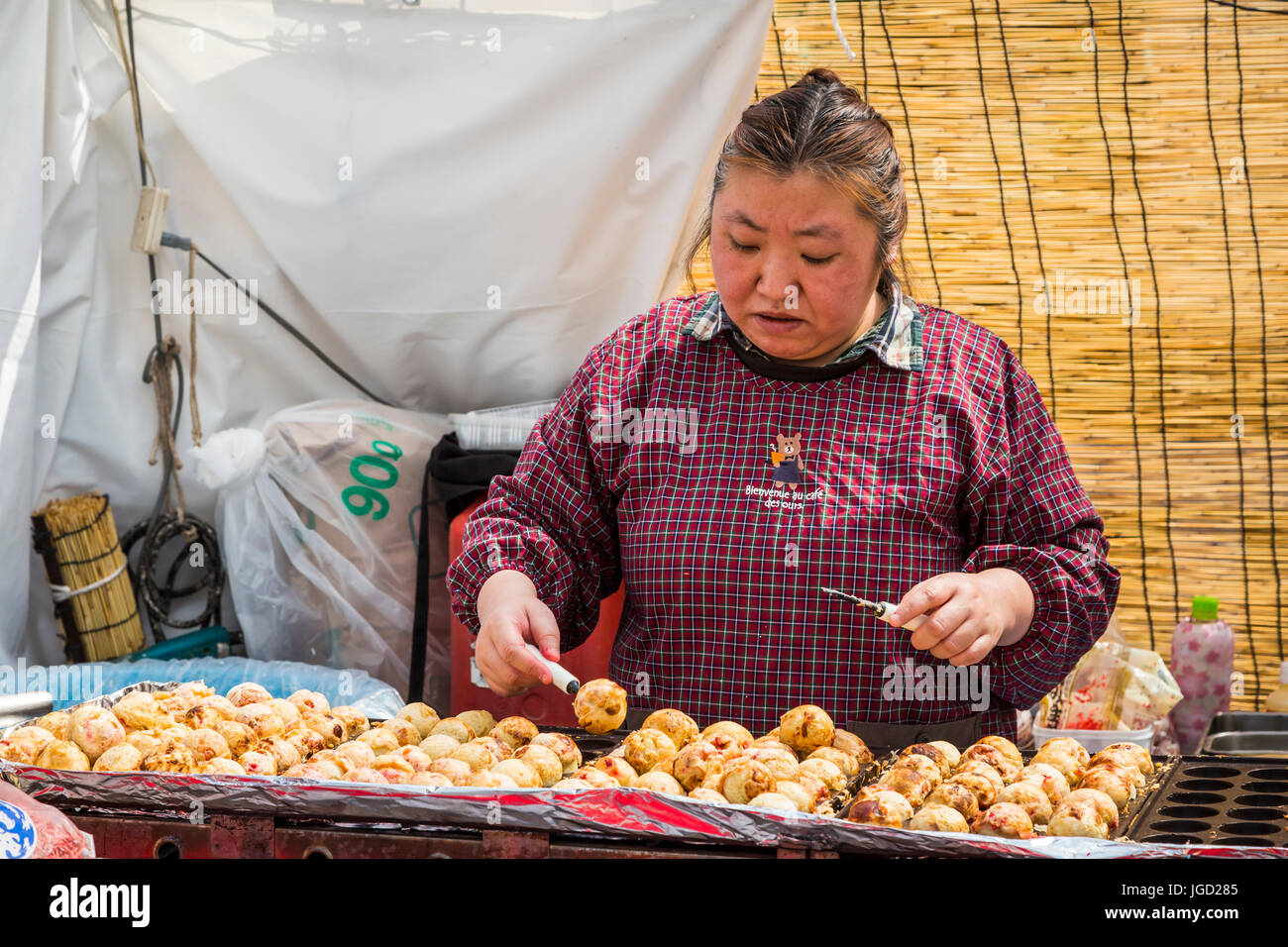 A street food vendor preparing traditional Japanese dishes in Asakusa ...