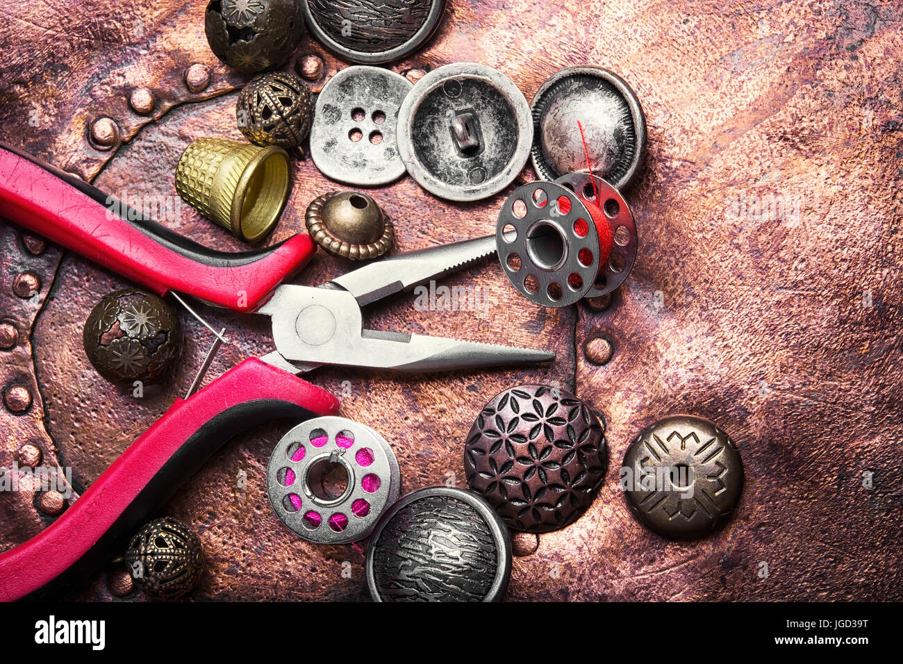 metal sewing button and thread coil on copper retro background Stock ...