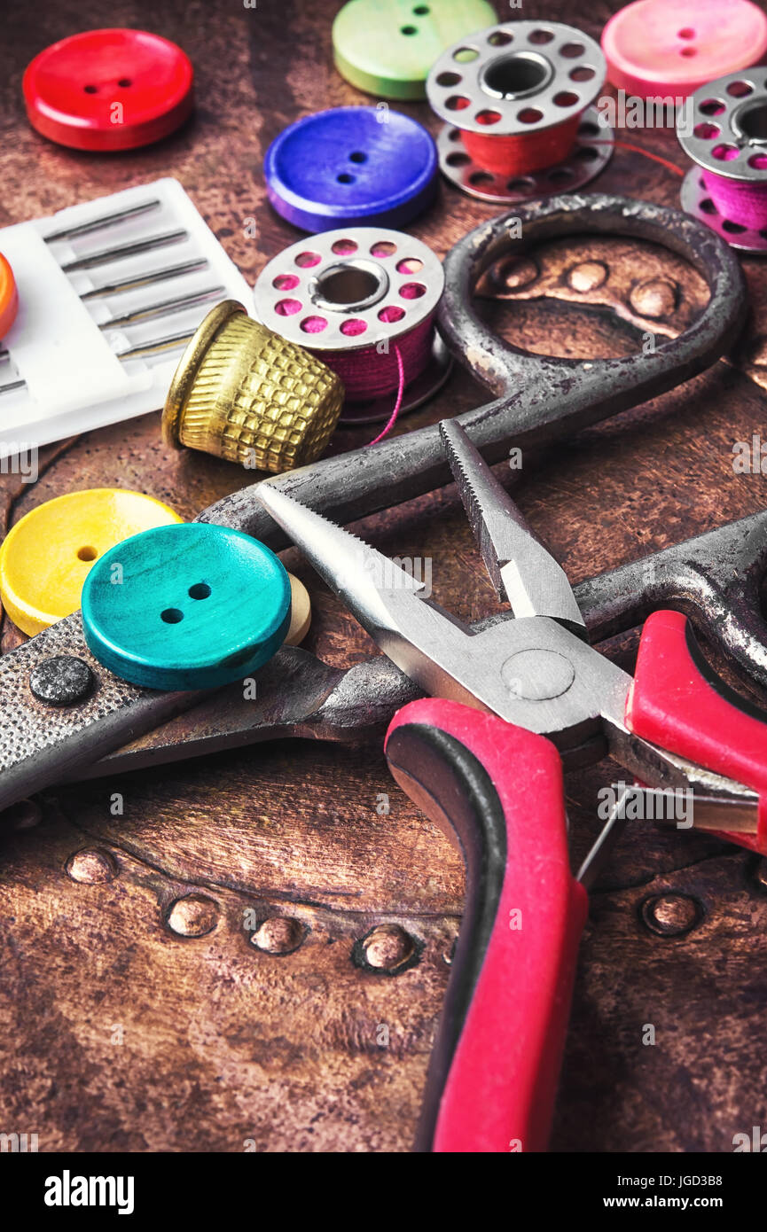 plastic sewing button and thread coil on a copper retro background ...