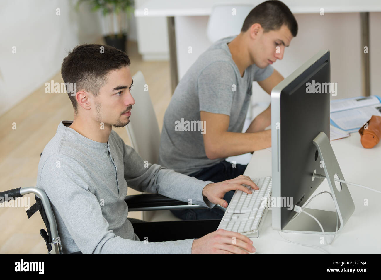 disabled young man in wheelchair doing homework Stock Photo - Alamy