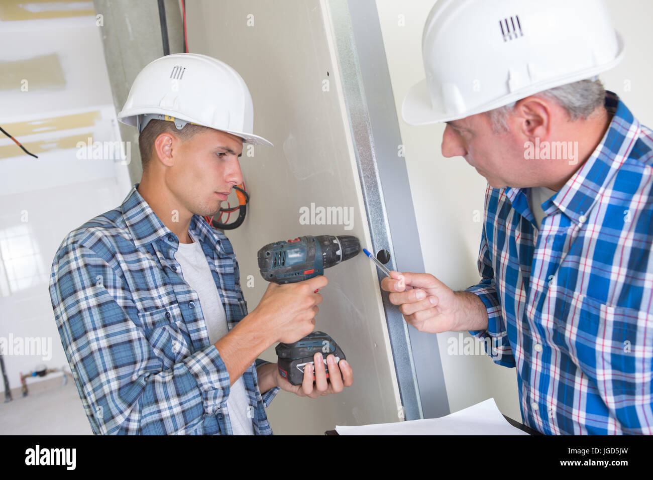 craftsman watching over his male apprentice Stock Photo - Alamy