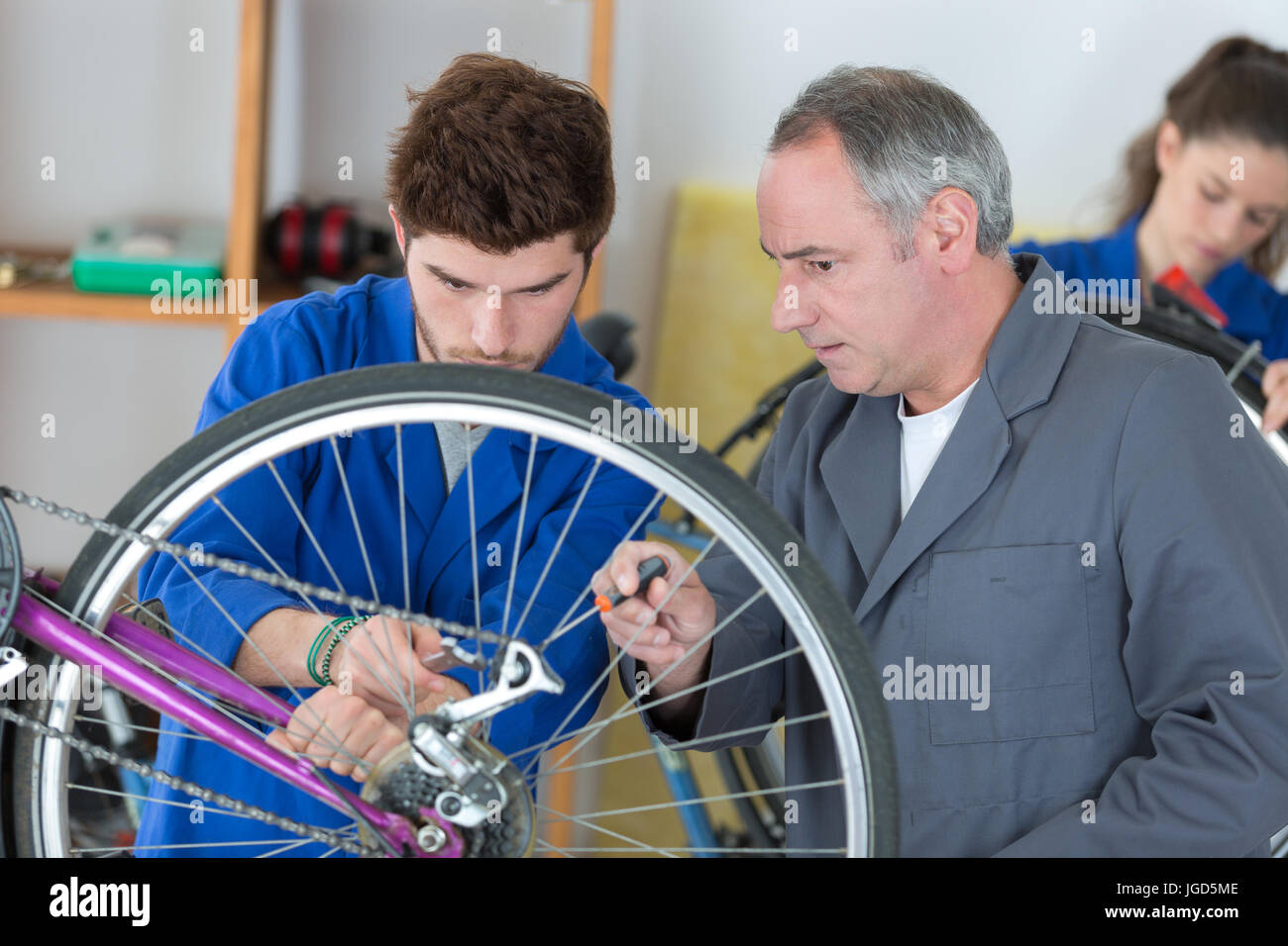 man working in bike workshop fixing bicycle spokes Stock Photo - Alamy
