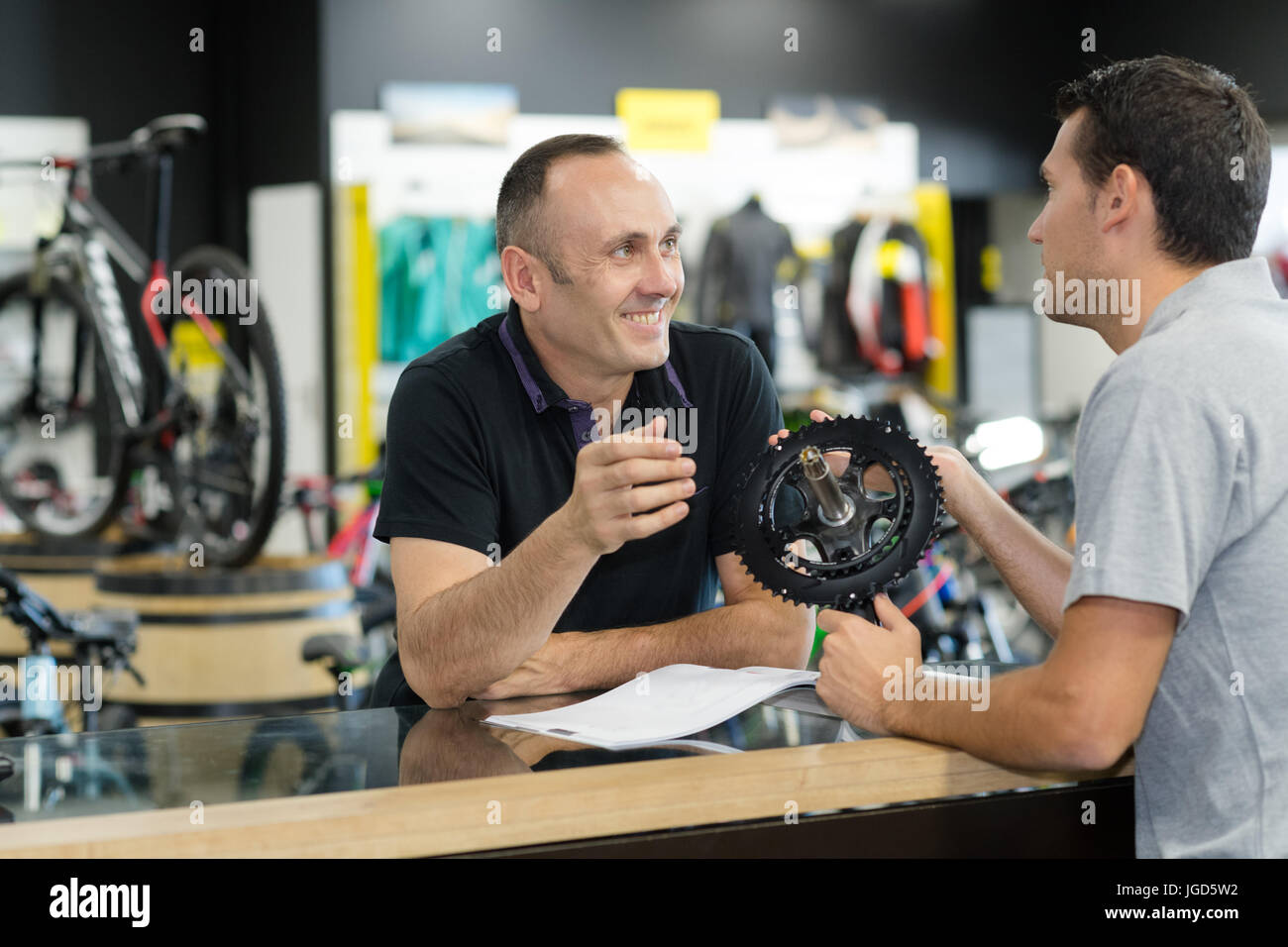 smiling craftsman in bike workshop with customer Stock Photo - Alamy