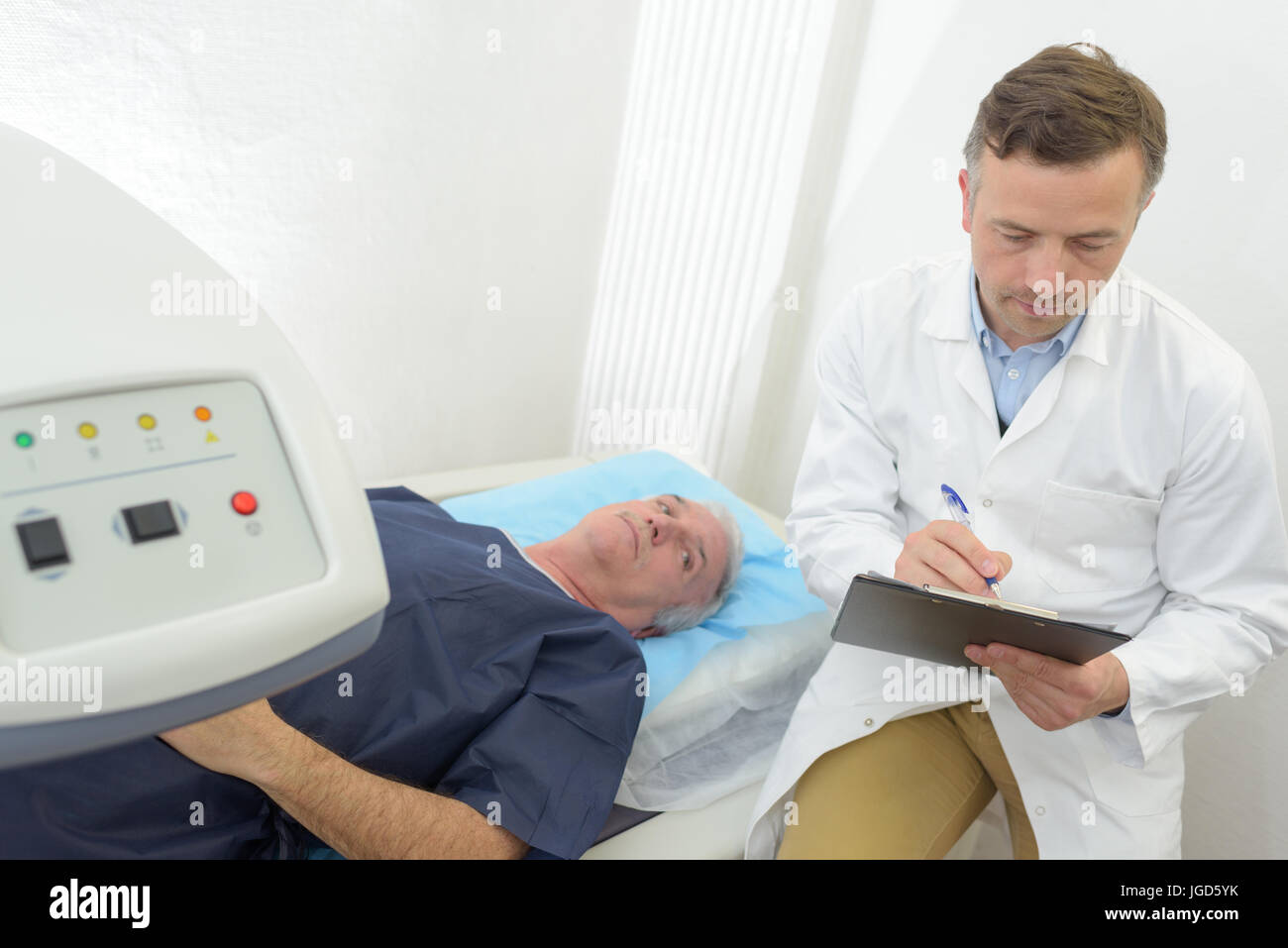doctor checking medical record of his patient during a scan Stock Photo ...