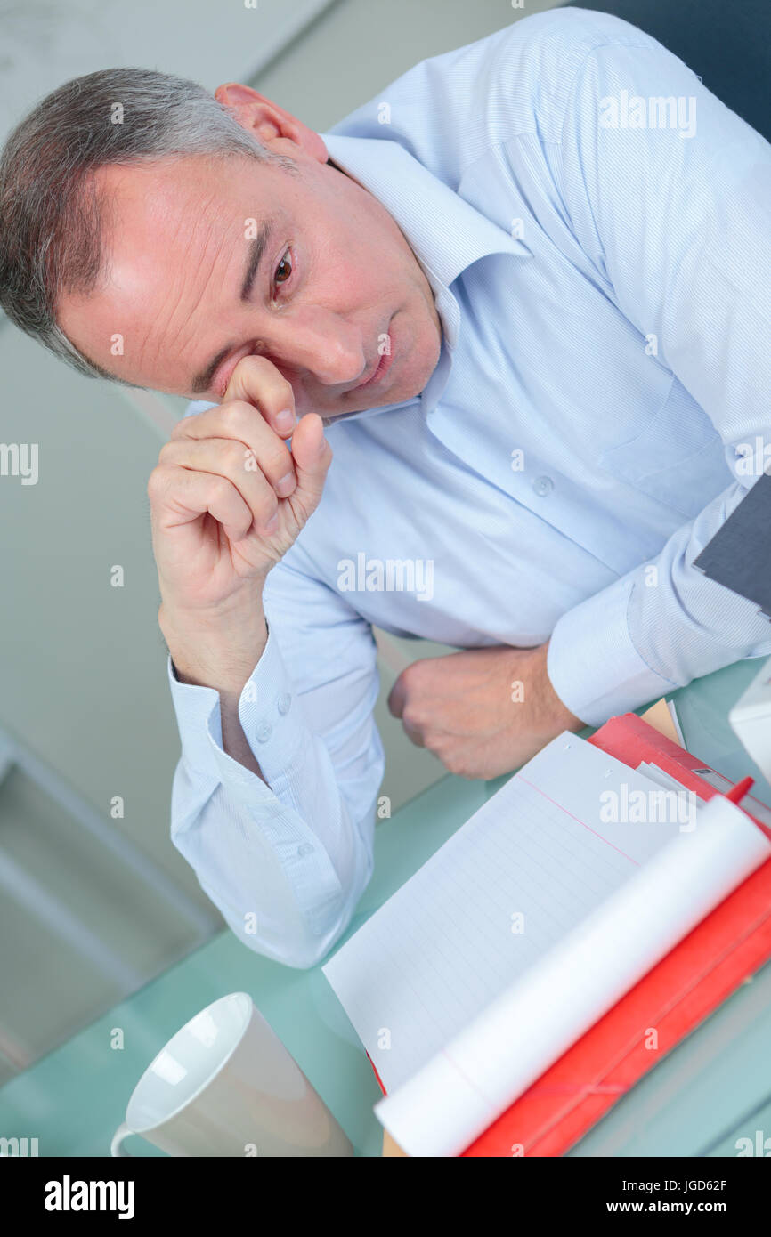 tired mature man sitting at the table Stock Photo - Alamy