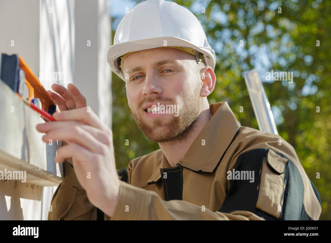 male contractor leveling a wall outdoors Stock Photo - Alamy