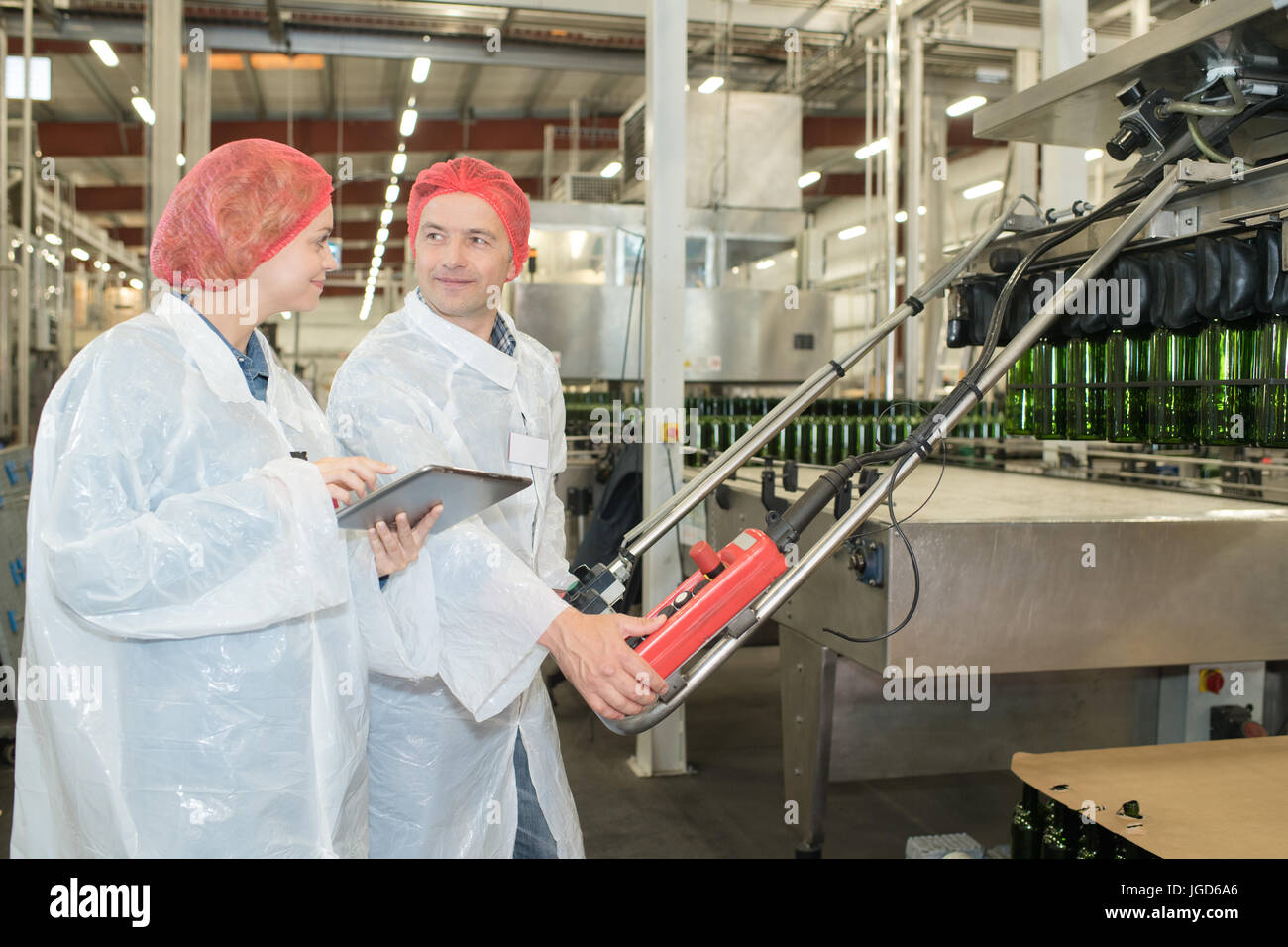 two serious manual workers doing their job on factory production Stock ...