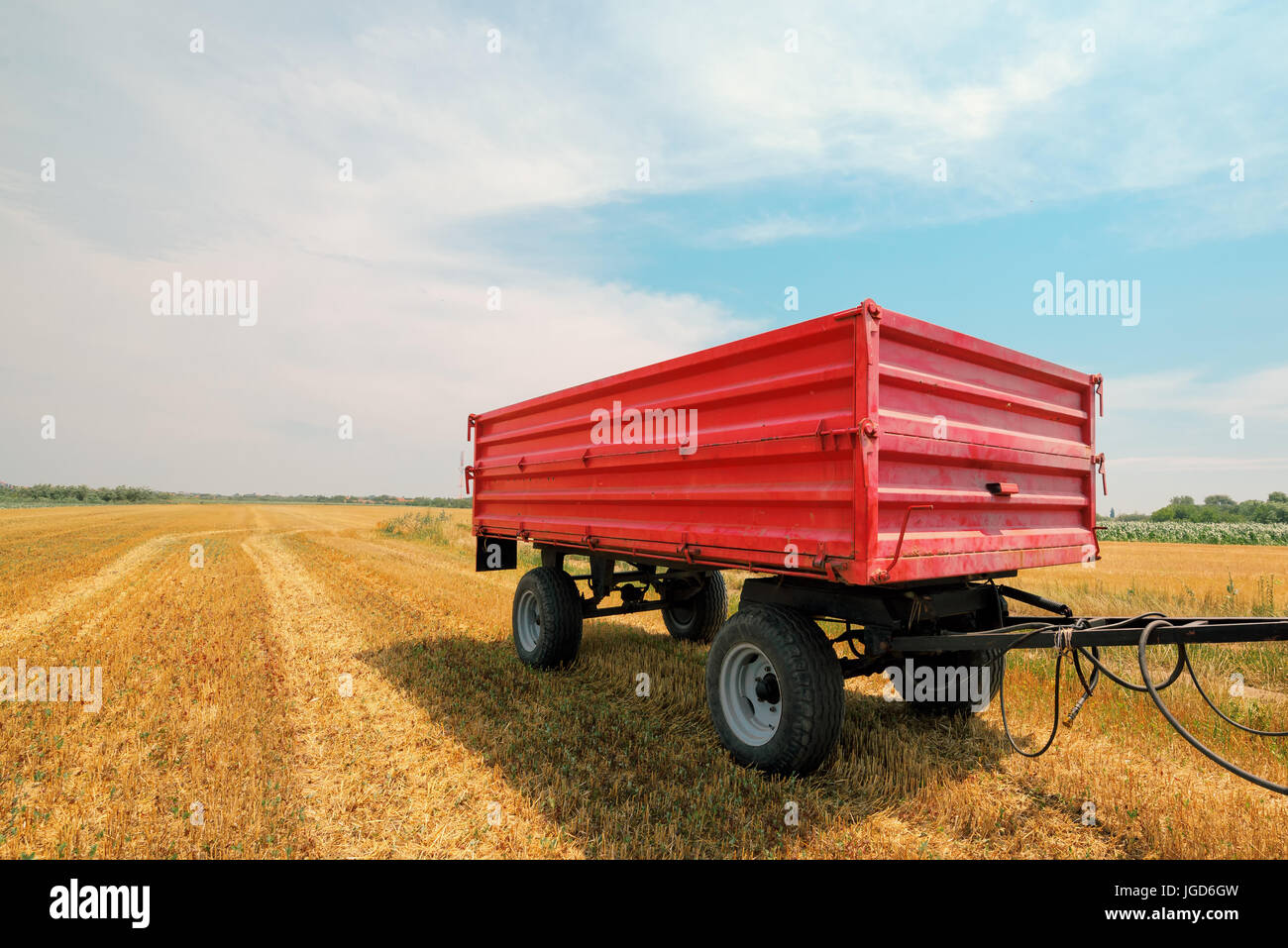 Agricultural tractor trailer in harvested wheat field Stock Photo - Alamy