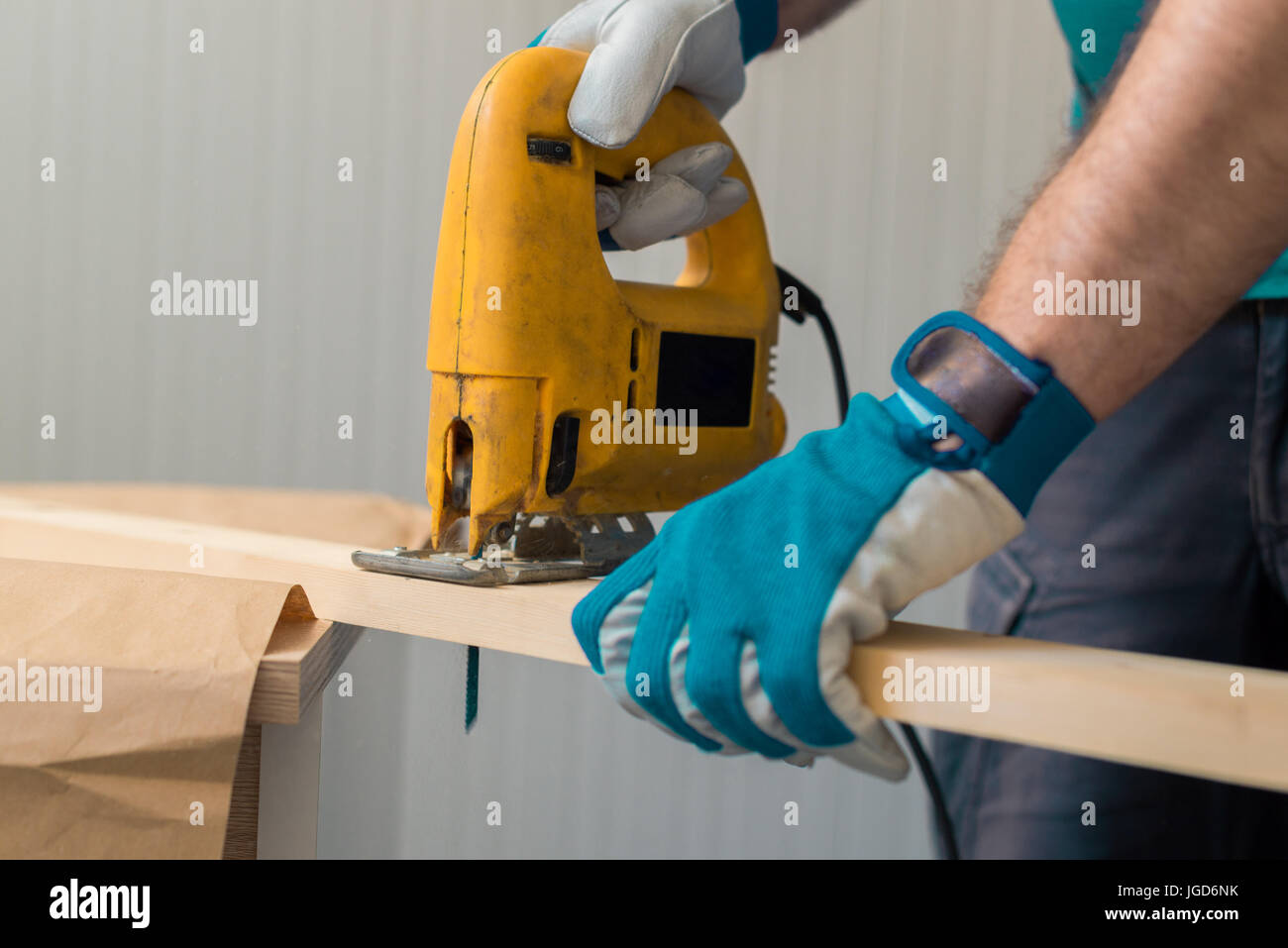 Carpenter handyman using electric handy saw on the woodwork workshop ...
