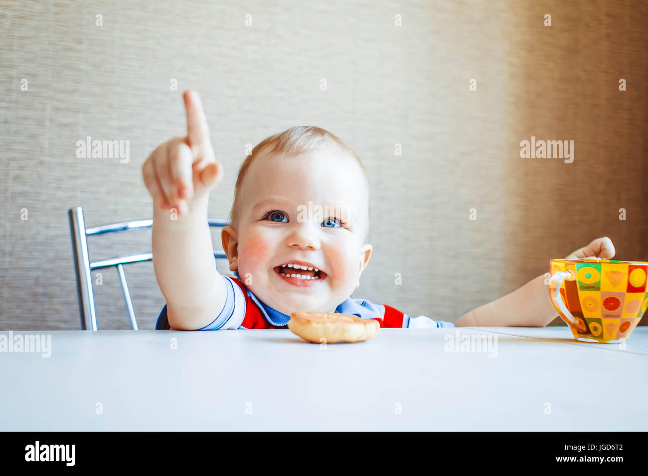 Little boy is sitting at the kitchen table Stock Photo - Alamy