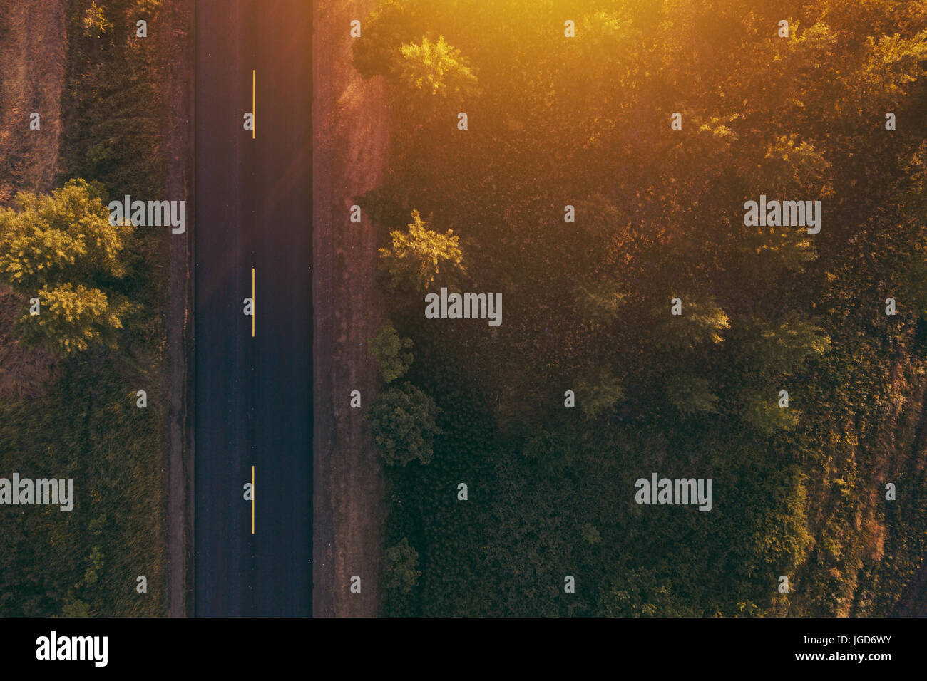 Empty straight road through countryside in sunset, aerial view from ...