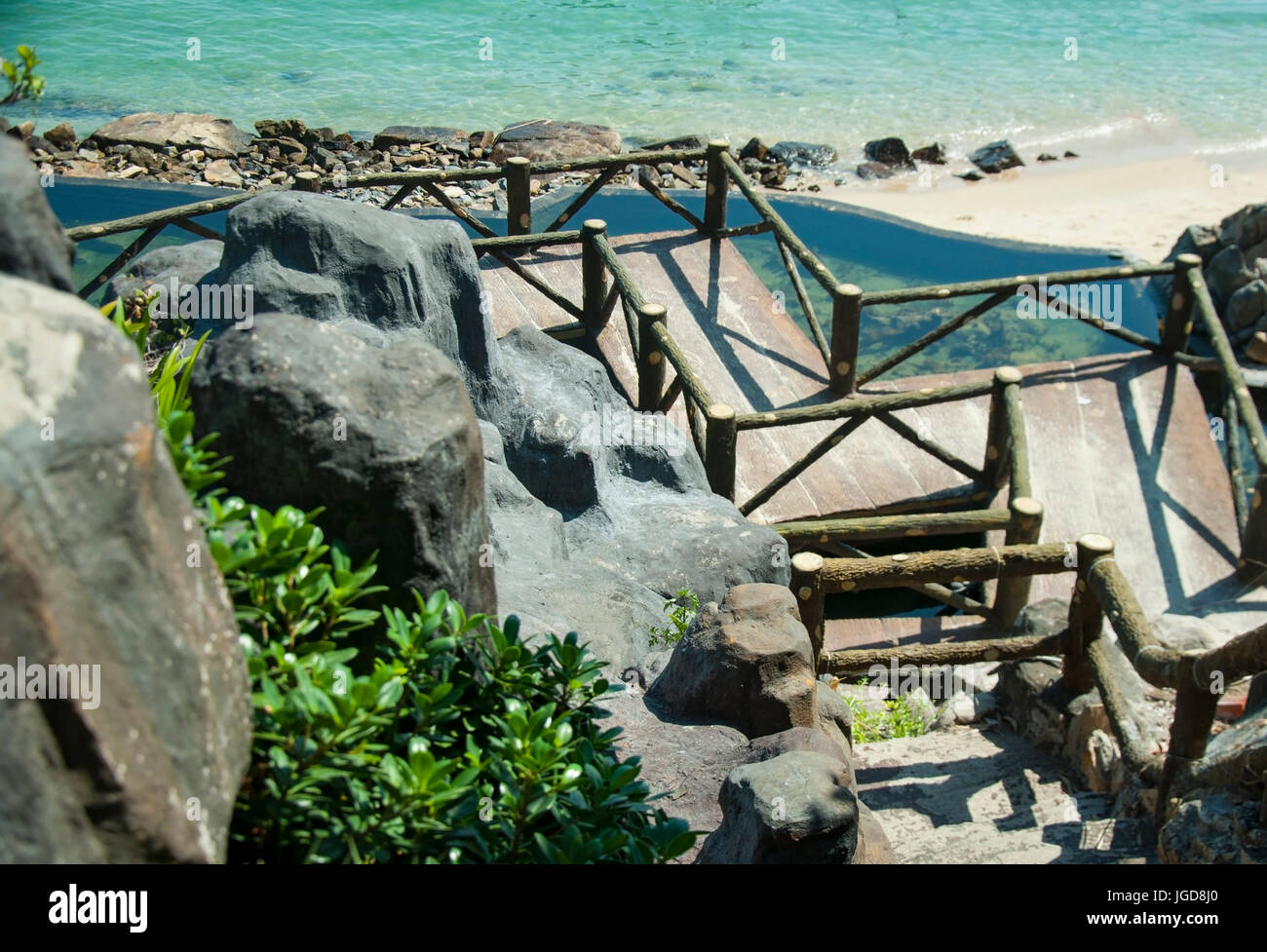 Stairs from the mountain slope to the sandy beach by the sea Stock ...