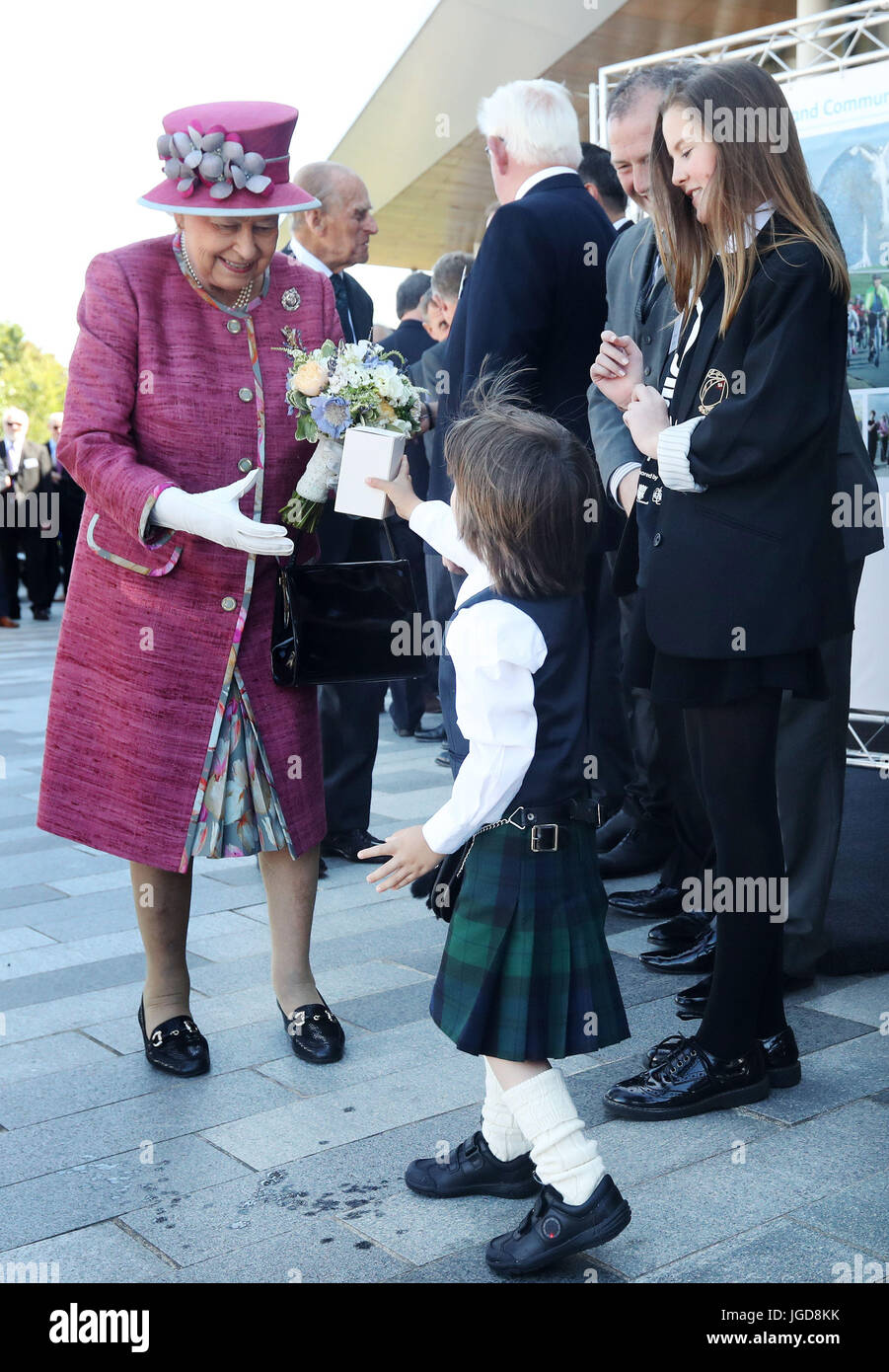 Five-year-old Sam Mitchell gives Queen Elizabeth II a present during a ...