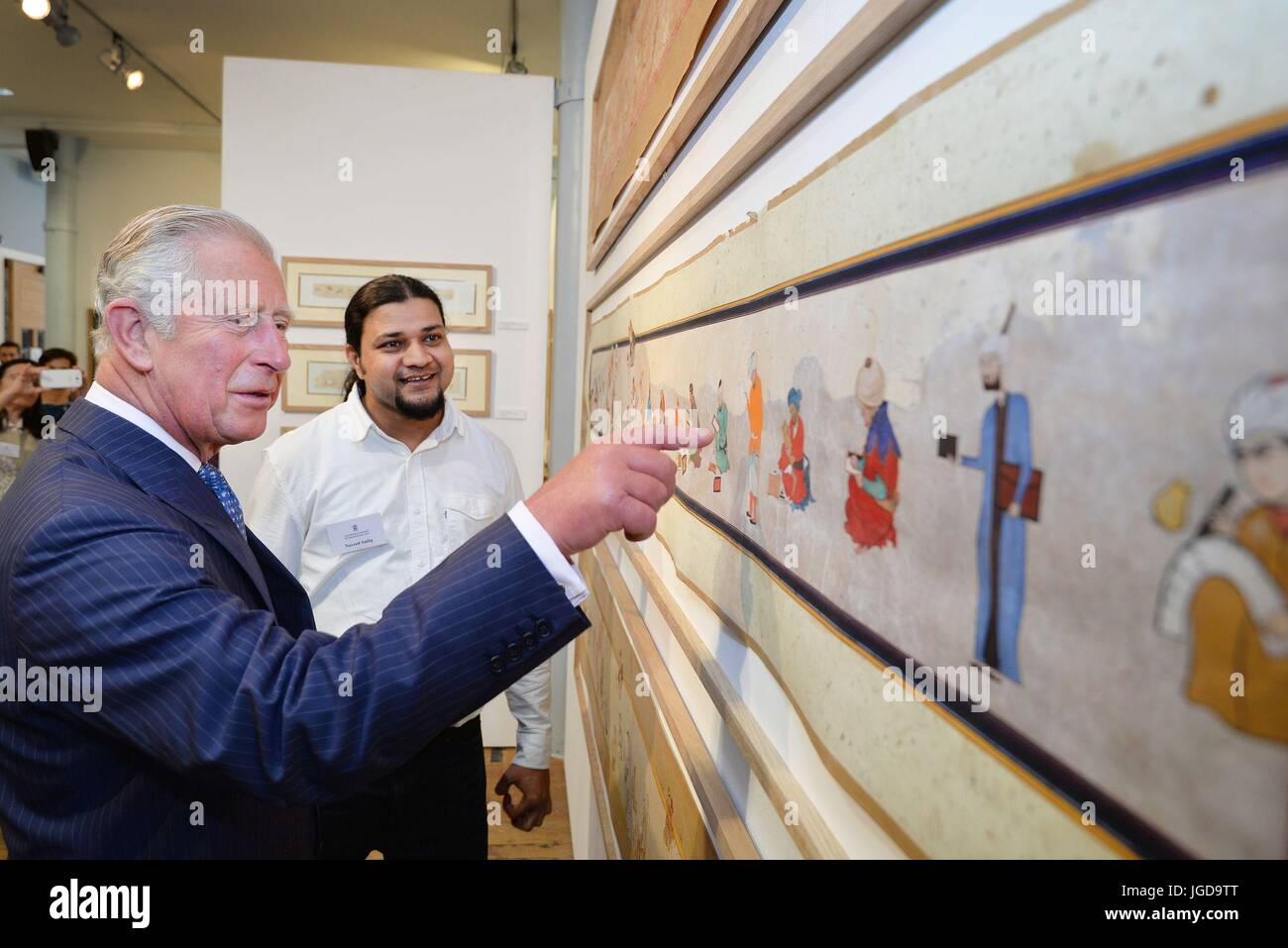The Prince of Wales studies the work of Artist Naveed Sadiq during a ...