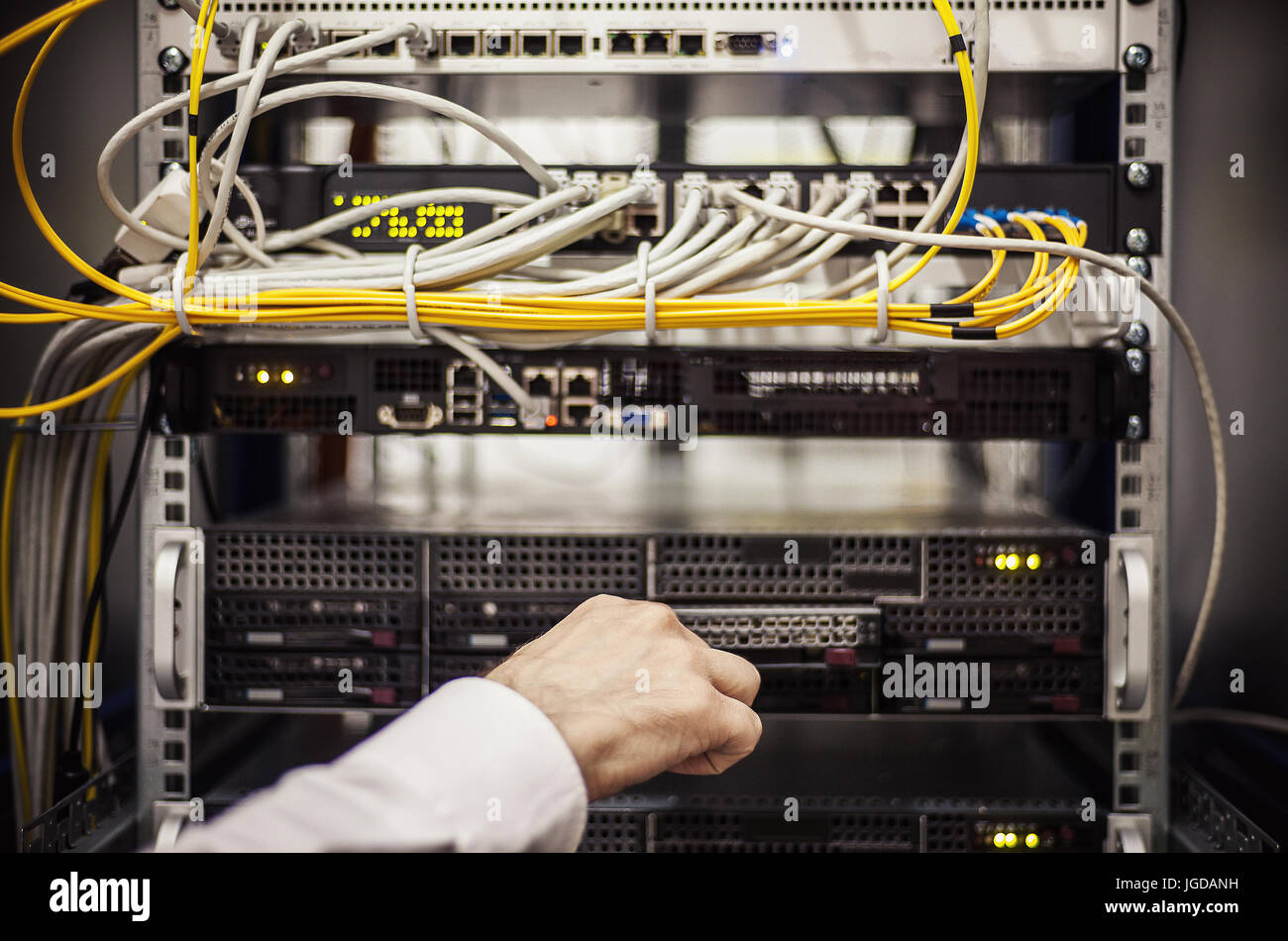 Man's hand connecting cables on modern computer peripheral hardware ...