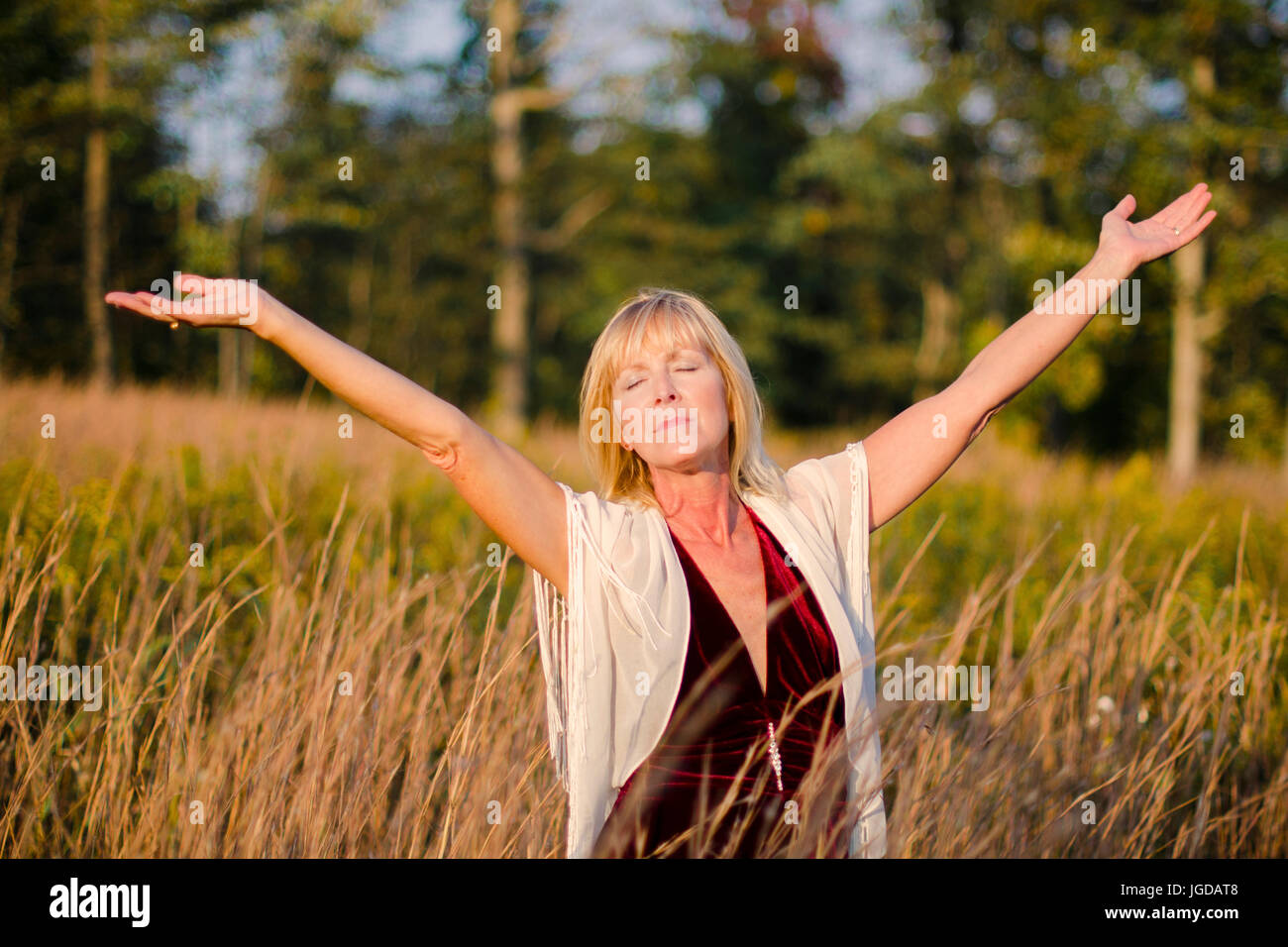 Woman doing sun solution at sunset Stock Photo - Alamy