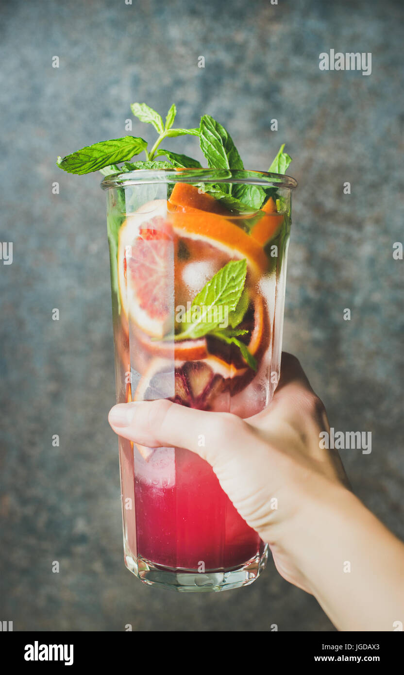 Woman's hand holding glass of homemade blood orange citrus lemonade ...