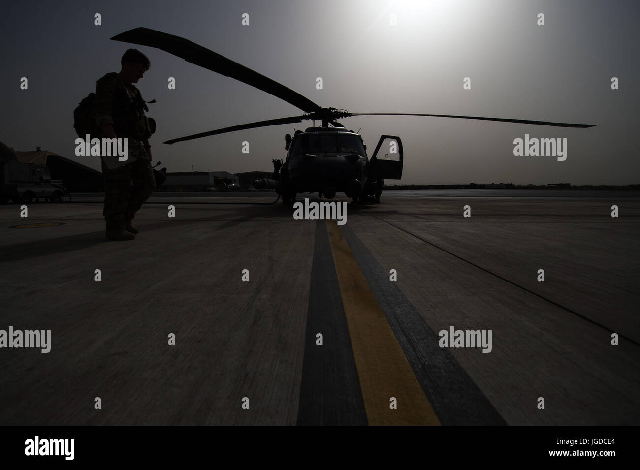 An Airman from the 303rd Expeditionary Rescue Squadron steps to an HH ...
