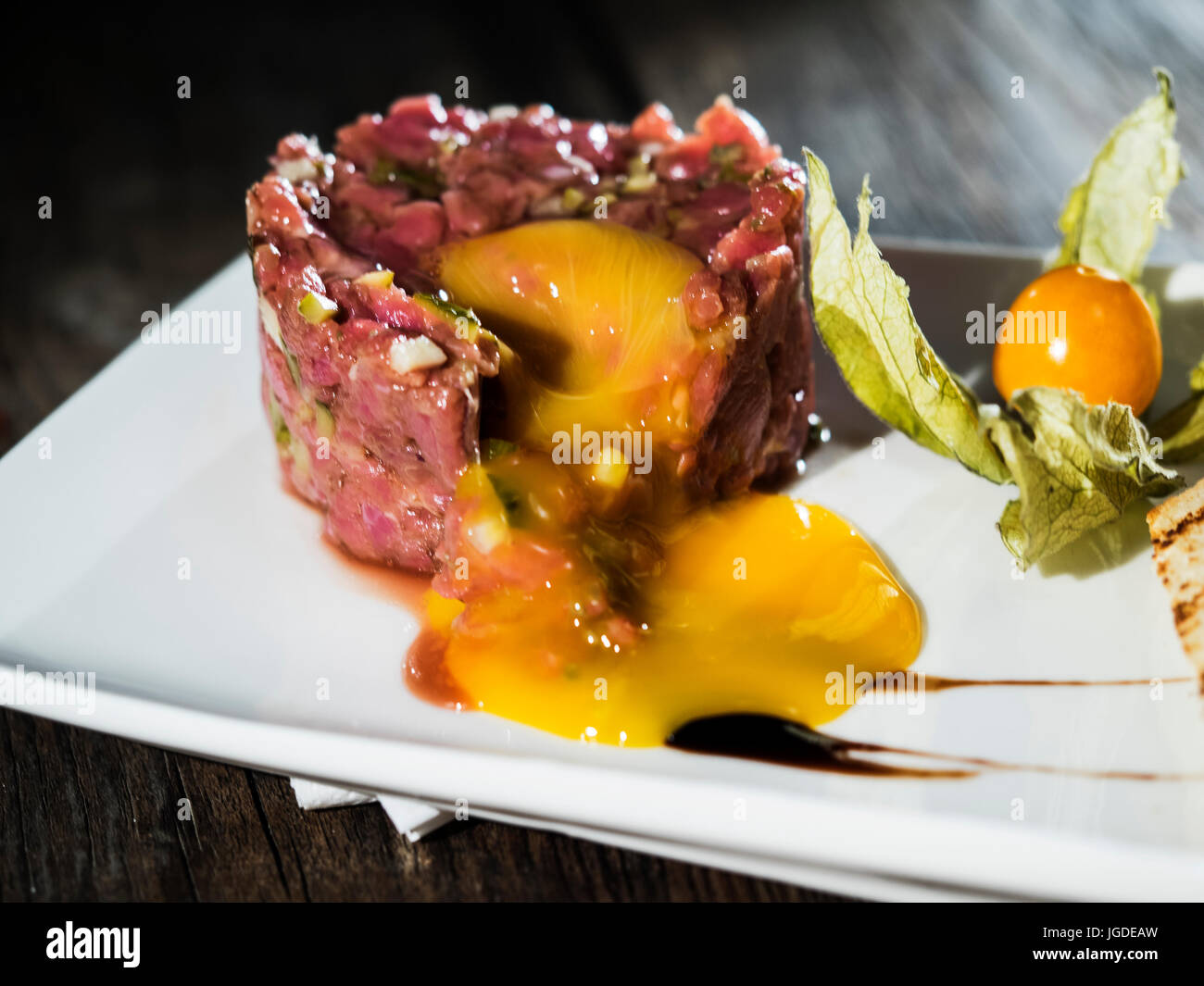 Raw steak tatar with egg yolk Stock Photo - Alamy