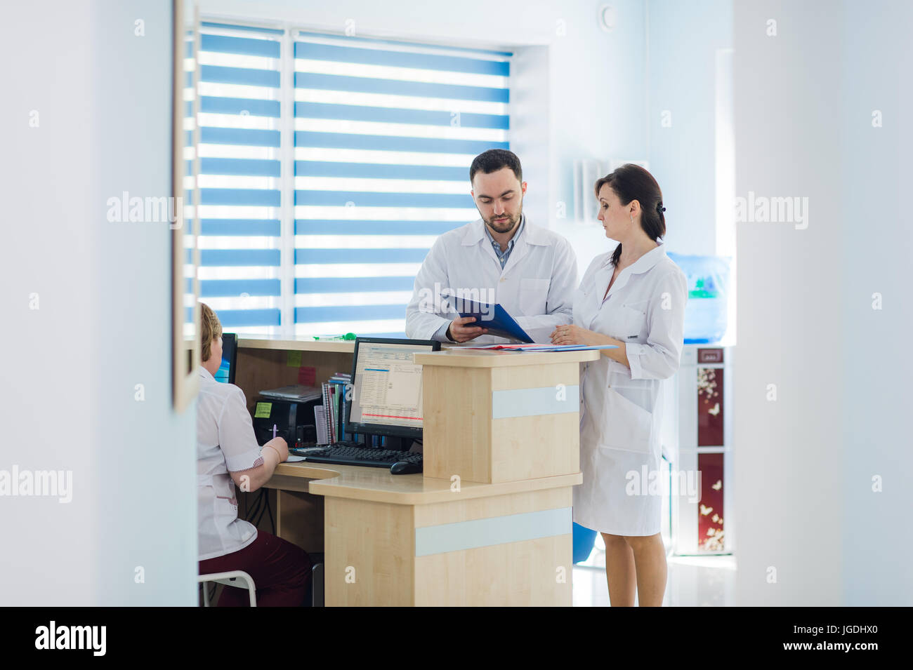 Busy reception in a hospital with doctors and receptionists Stock Photo ...