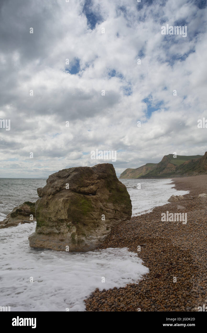 Costal seaside view with large rock in foreground on a cloudy day ...