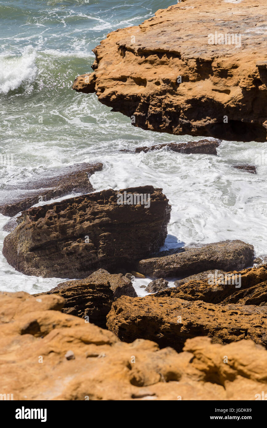 view on coast line rocks in ocean with splash waves Stock Photo - Alamy