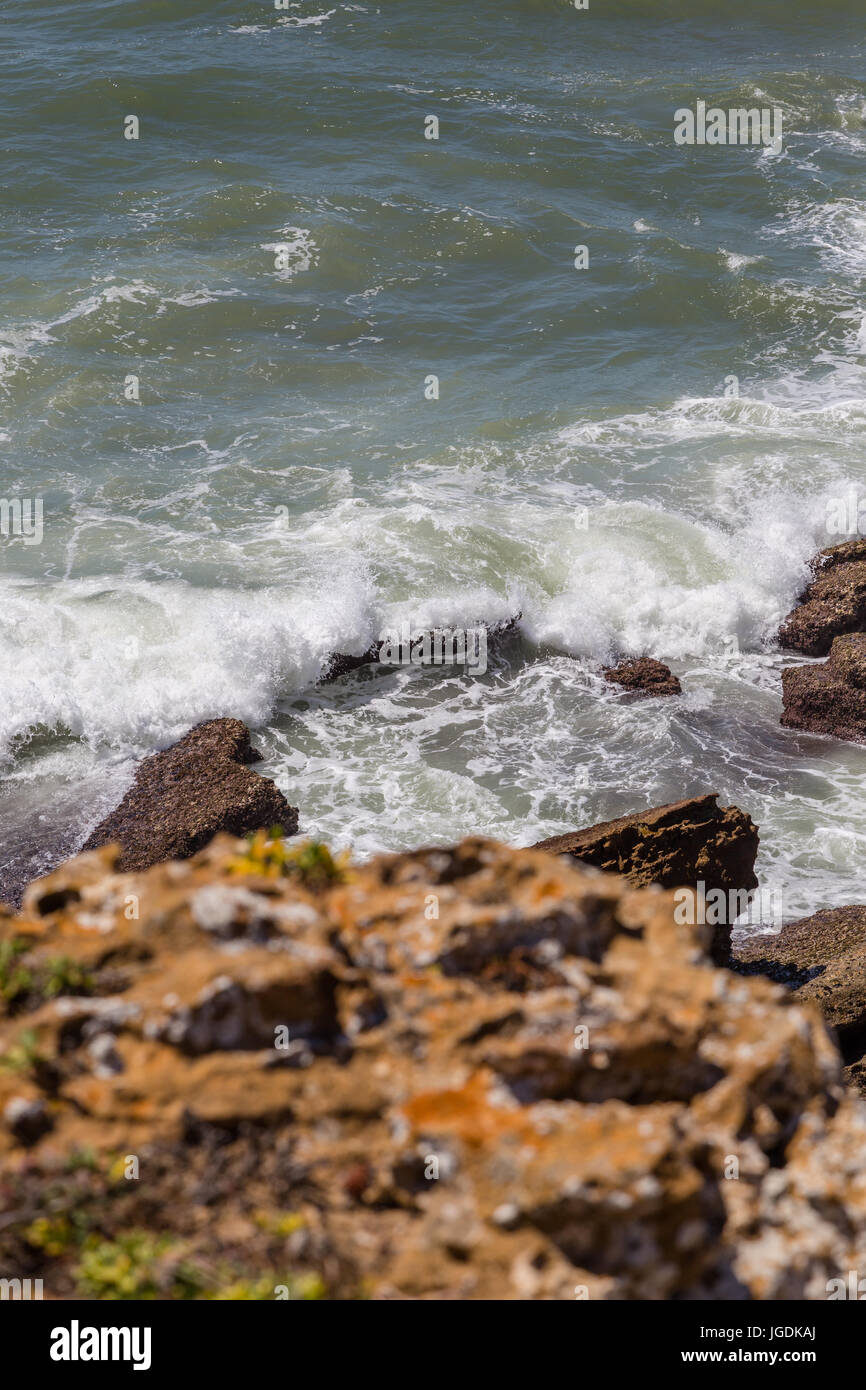 view on coast line rocks in ocean with splash waves Stock Photo - Alamy