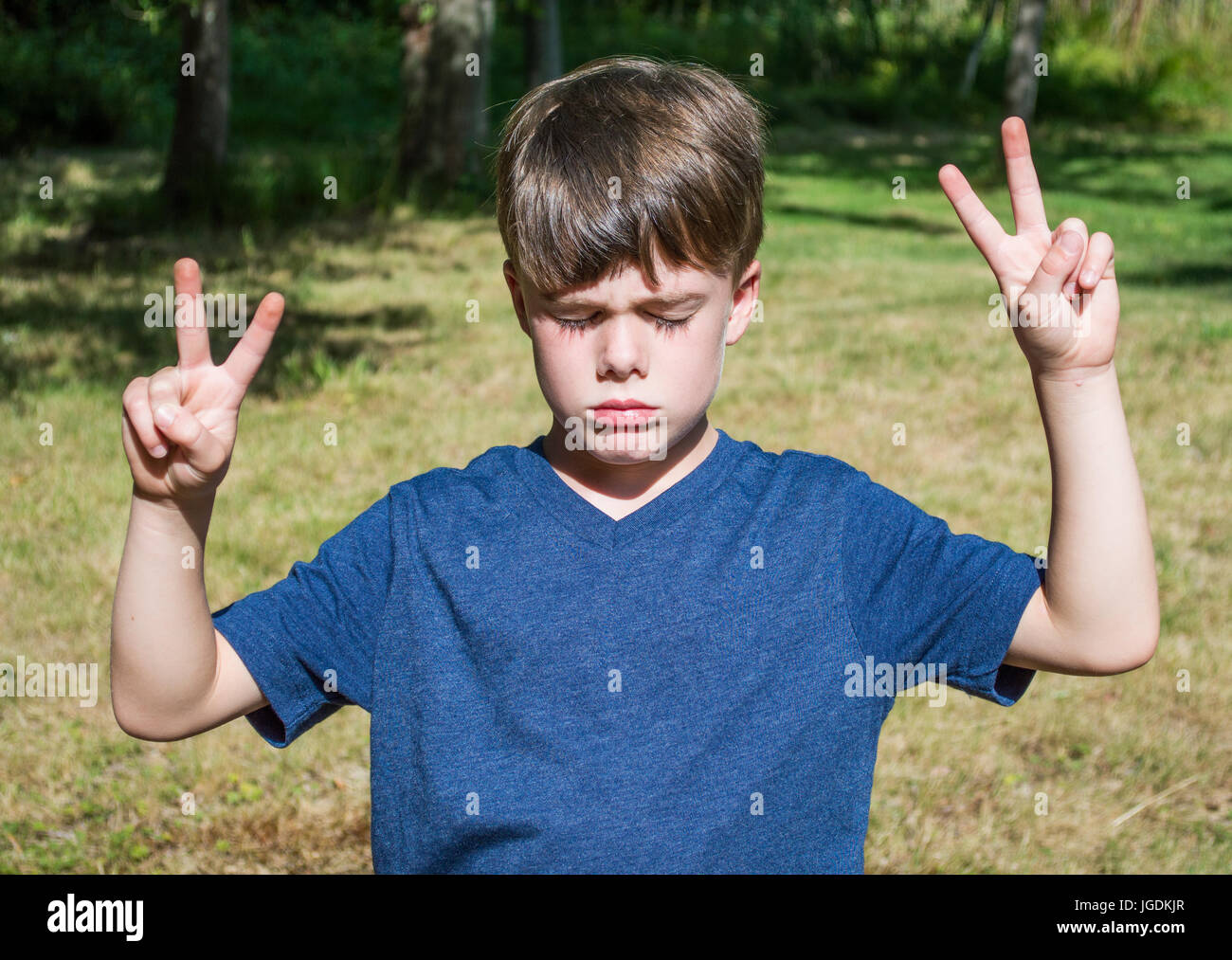 caucasian young boy making peace signs with his fingers outdoors Stock ...