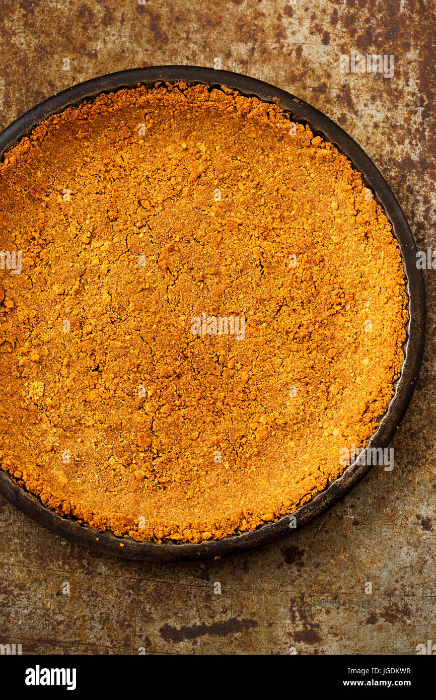 Baked pie base pastry made from crushed biscuits and butter in tart pan ...