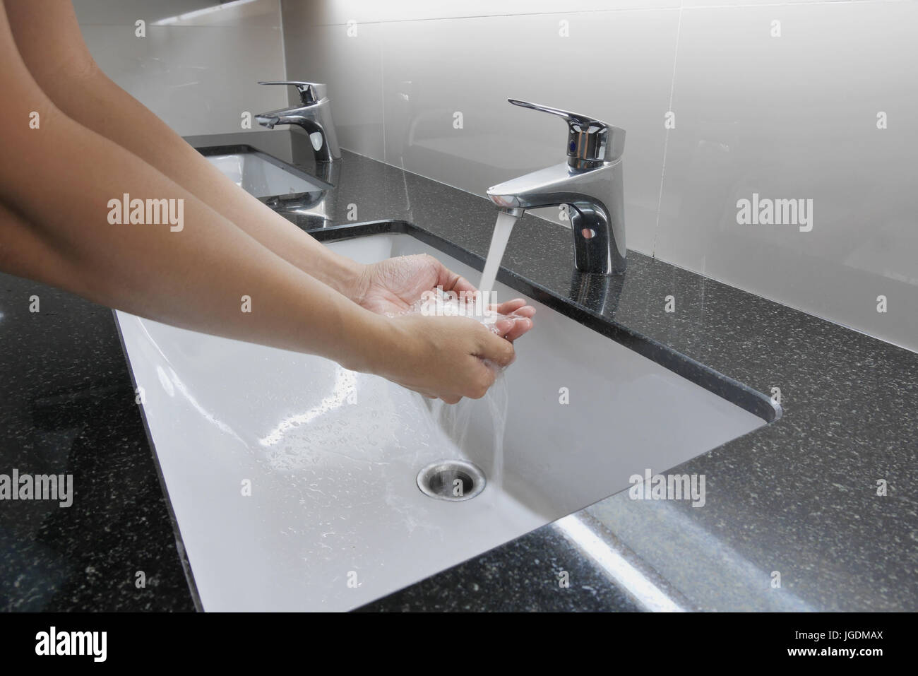white washbasin and faucet on granite counter with hand washing Stock ...