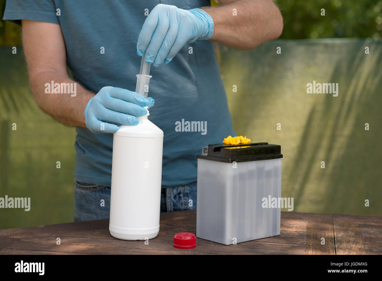 Filling a motorcycle battery with an acid Stock Photo - Alamy