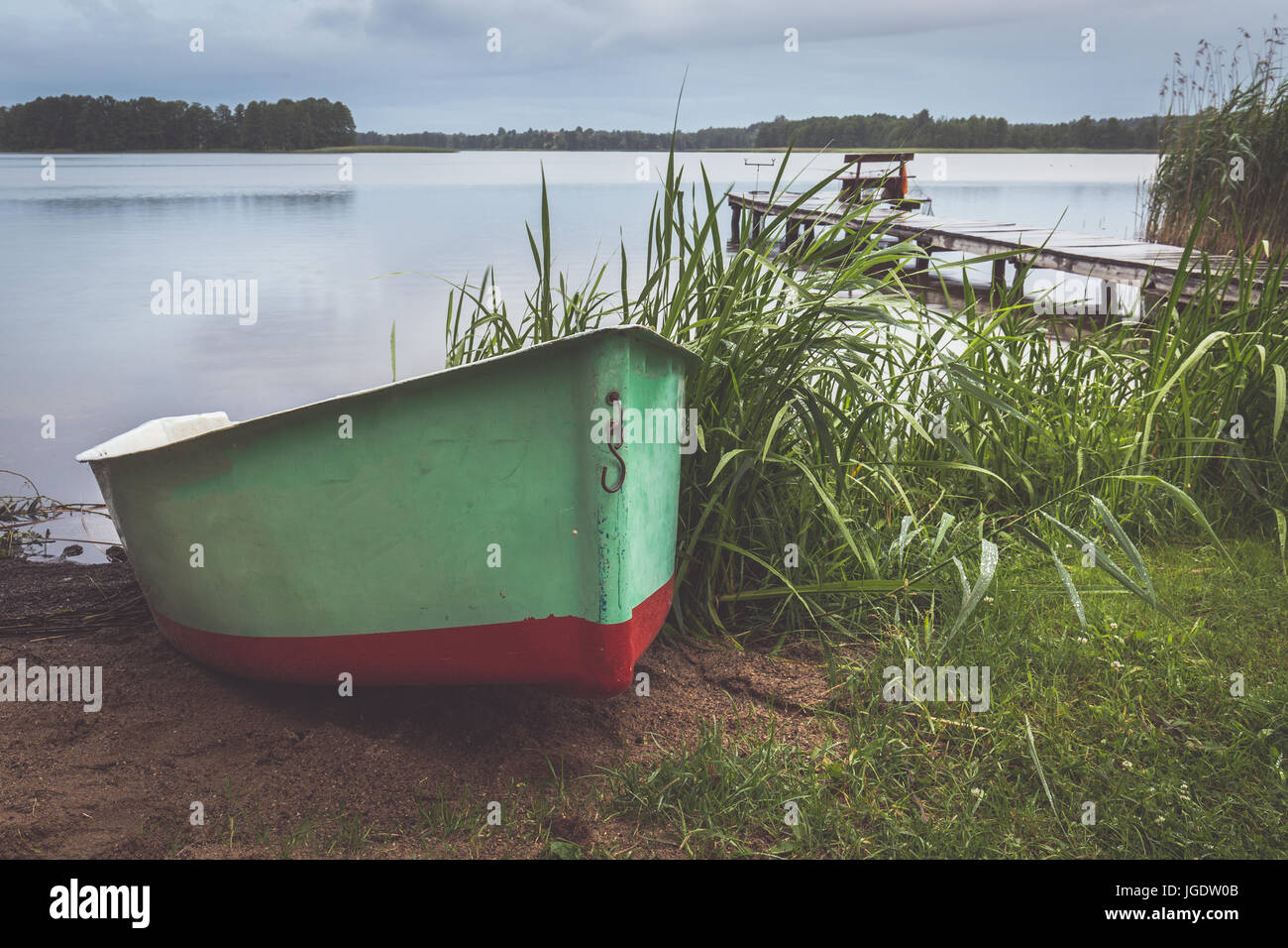 Fisherman's boat at rainy evening at Masuria lake. In background there ...