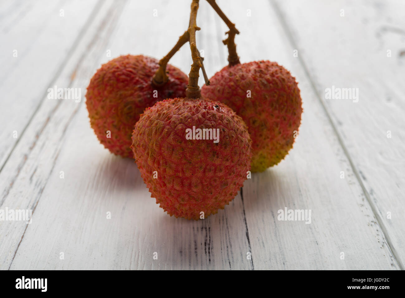 fresh lichees on white wood background Stock Photo - Alamy