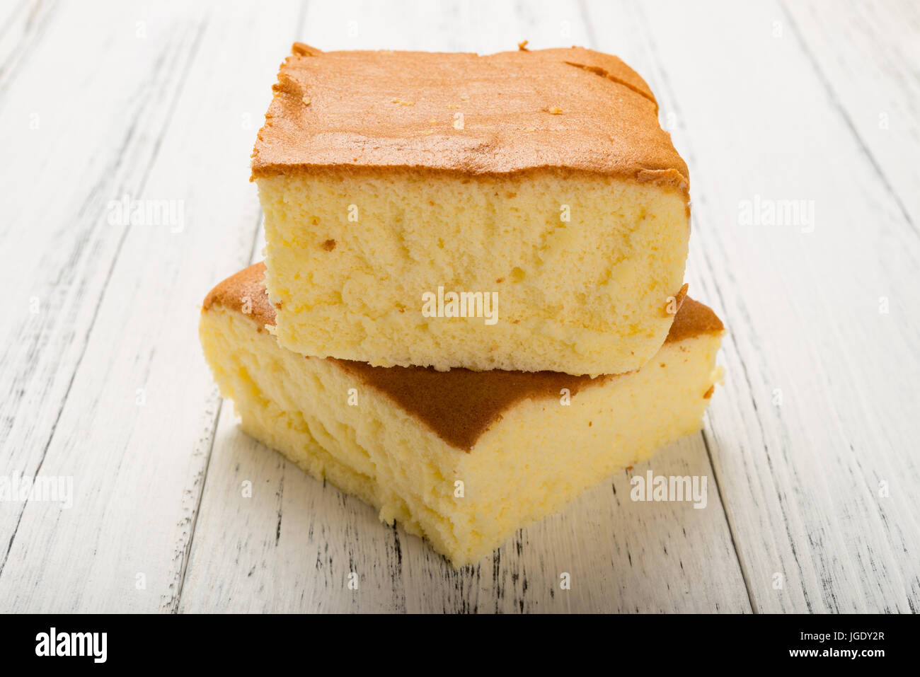 side view two sponge cakes on white wood background Stock Photo - Alamy
