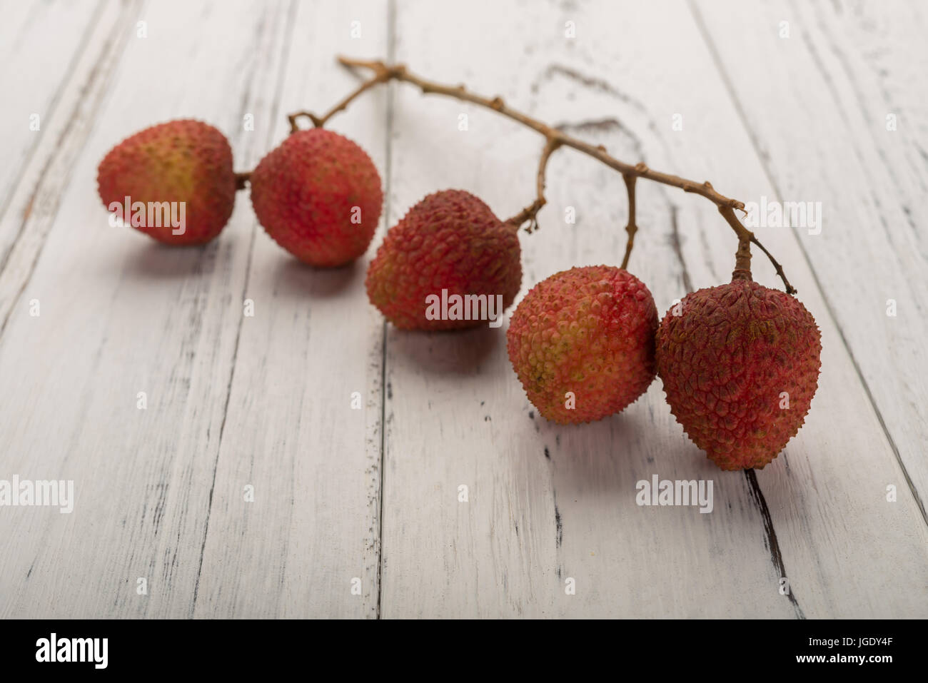 branch of fresh lichees on white wood background Stock Photo - Alamy
