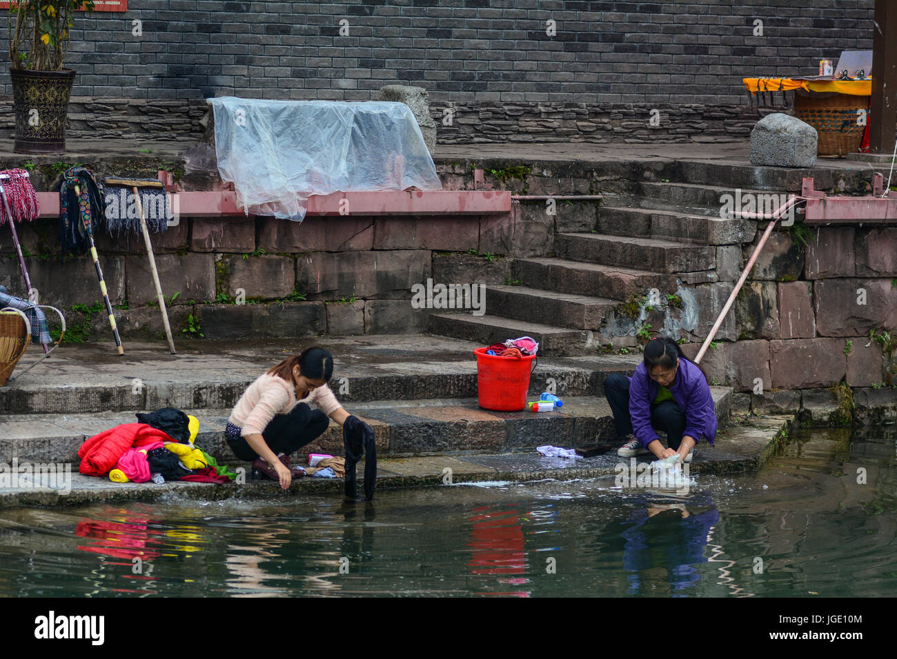 Hunan, China - Nov 6, 2015. Women wash clothes on riverbank at ...