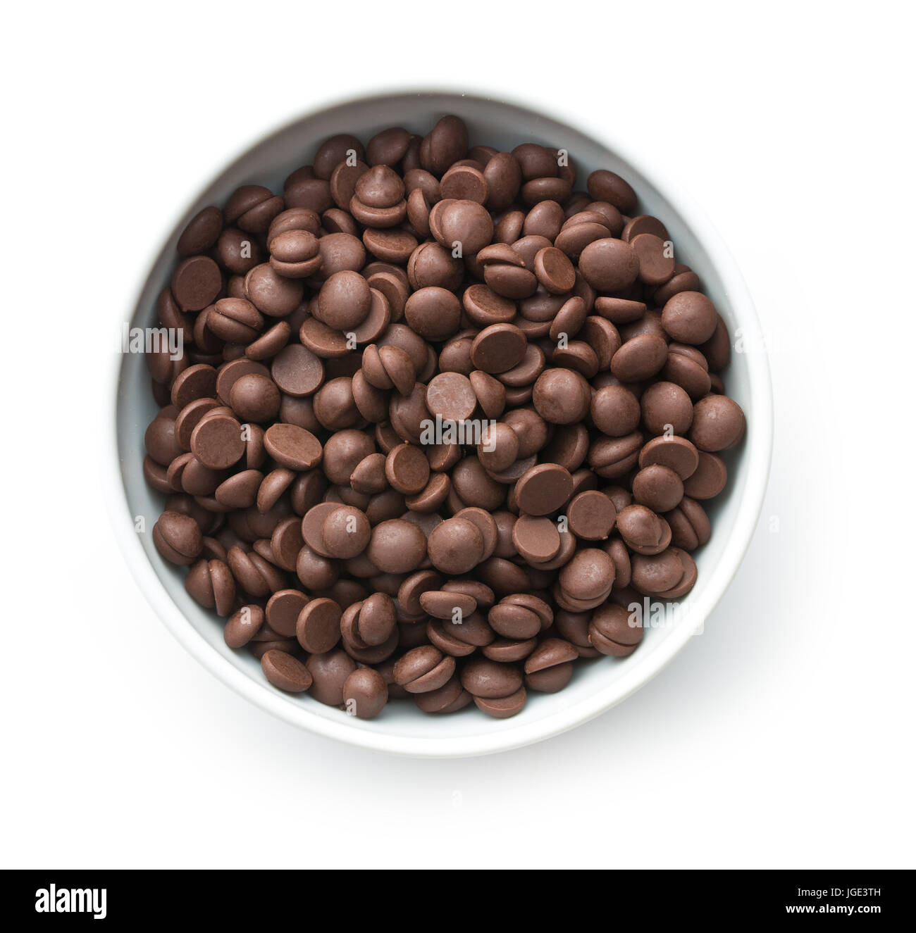 Tasty chocolate morsels in bowl isolated on white background. Top view ...