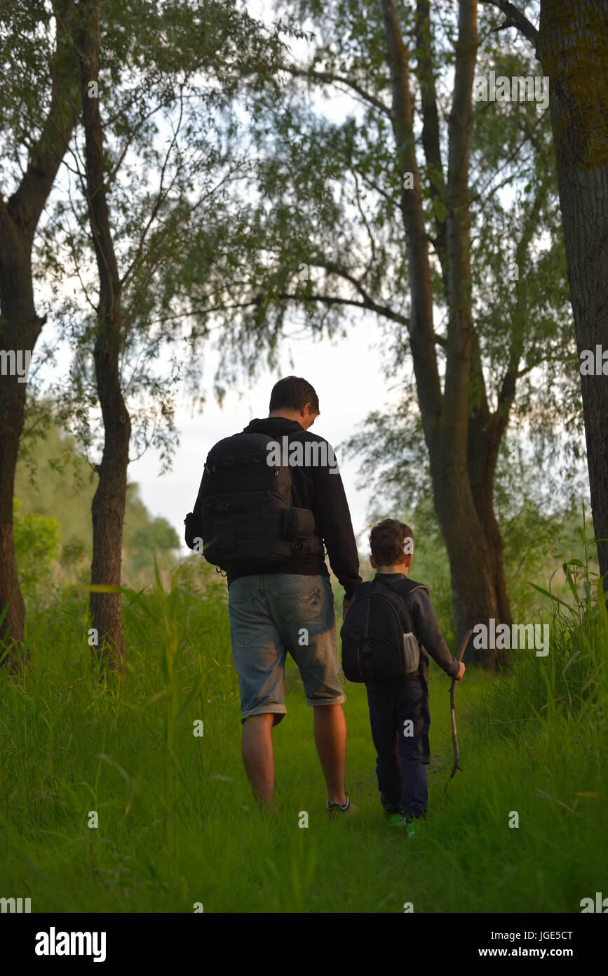 Father and son walking into the forrest at sunset Stock Photo - Alamy