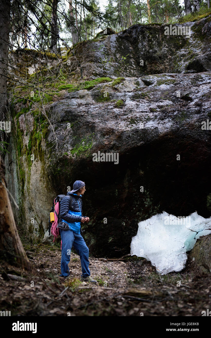 Young man hiking in scandinavia landscape, backpacker exploring melting ...