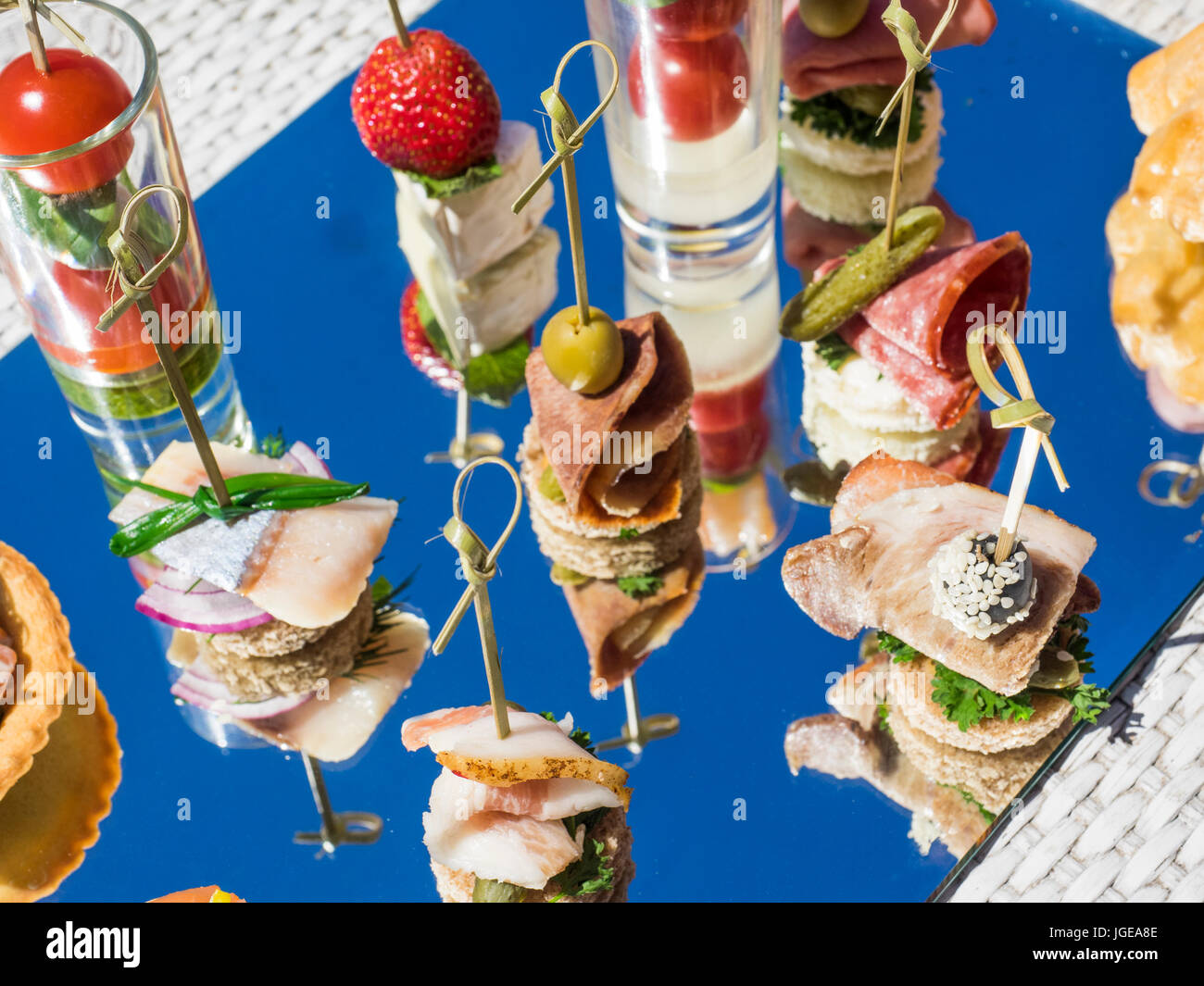 Set of different canapes and snacks served on a platter with a mirror ...