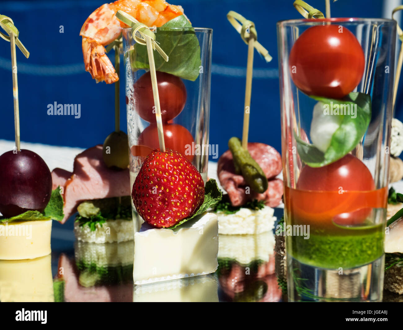 Set of different canapes and snacks served on a platter with a mirror ...