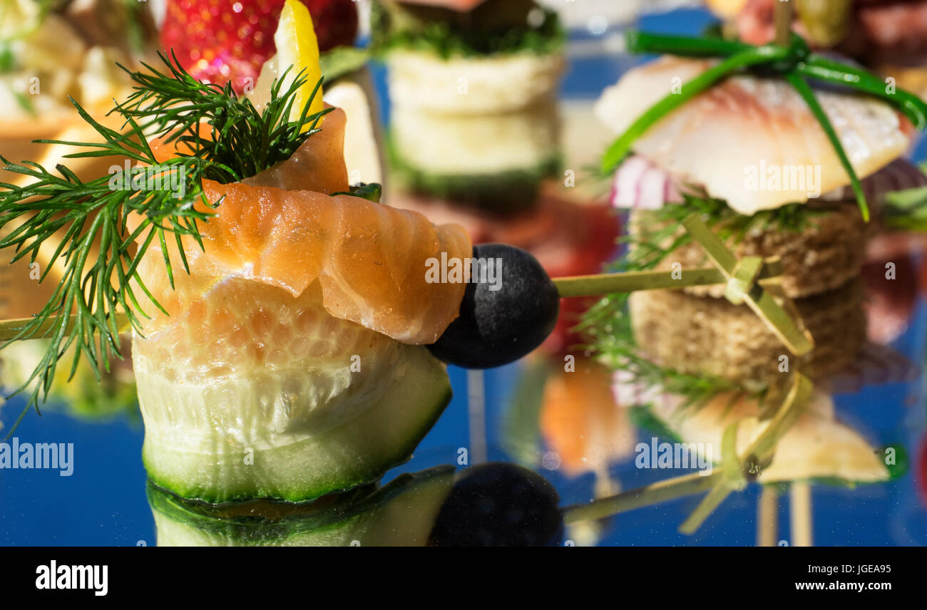 Set of different canapes and snacks served on a platter with a mirror ...