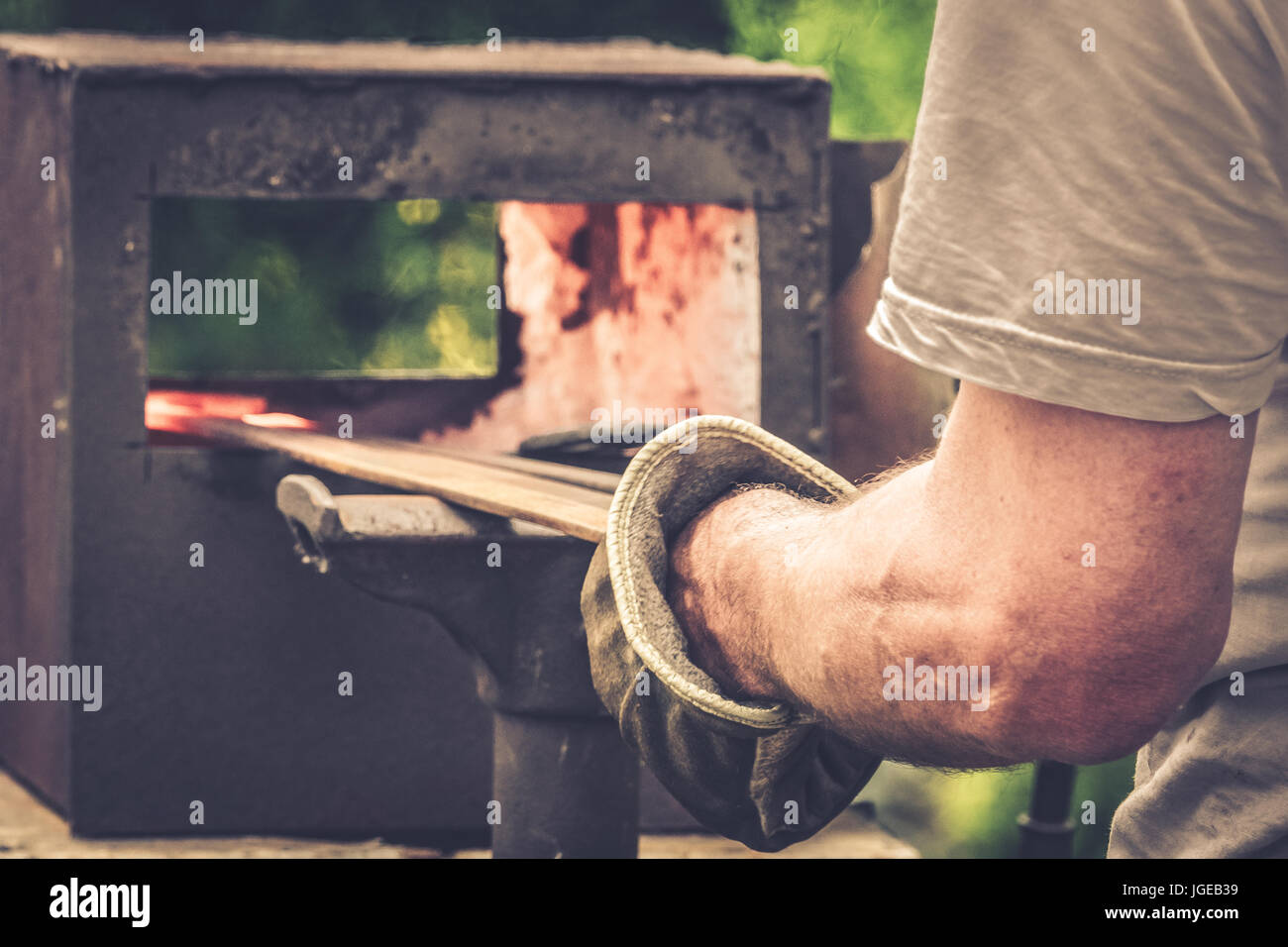A blacksmith inserting steel rods into the hot oven during medieval ...