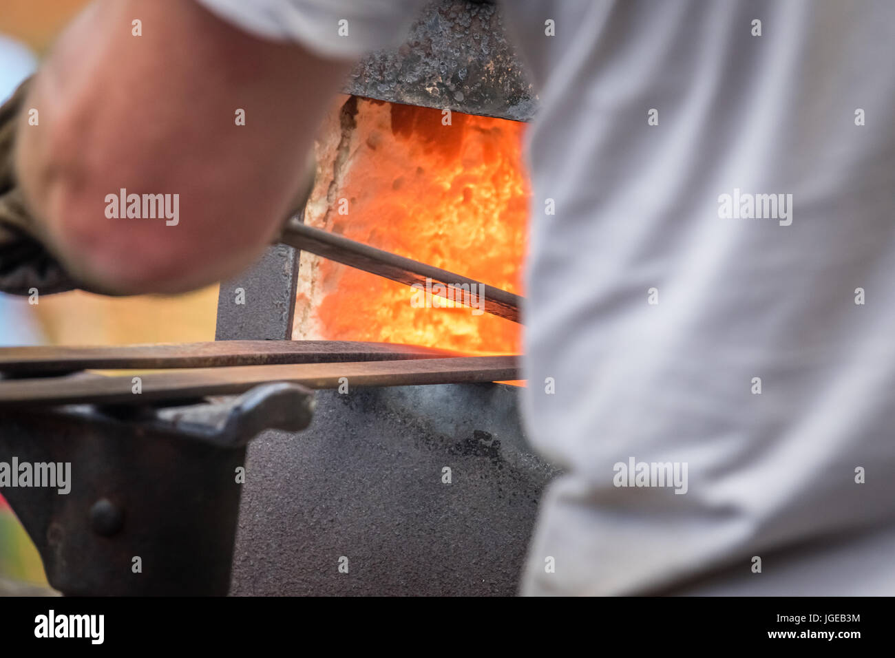 A blacksmith inserting steel rods into the hot oven during medieval ...
