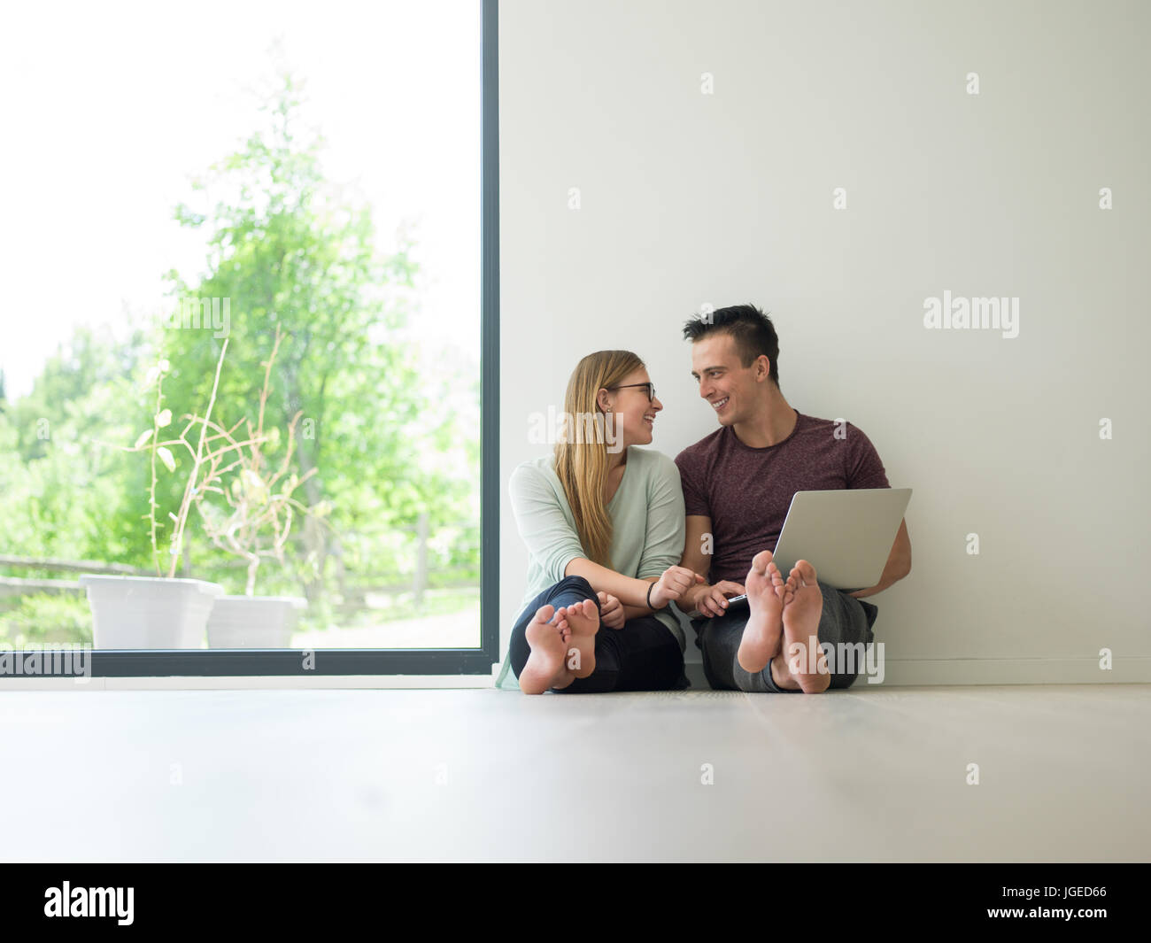 Young couple using laptop computer on the floor at luxury home together ...