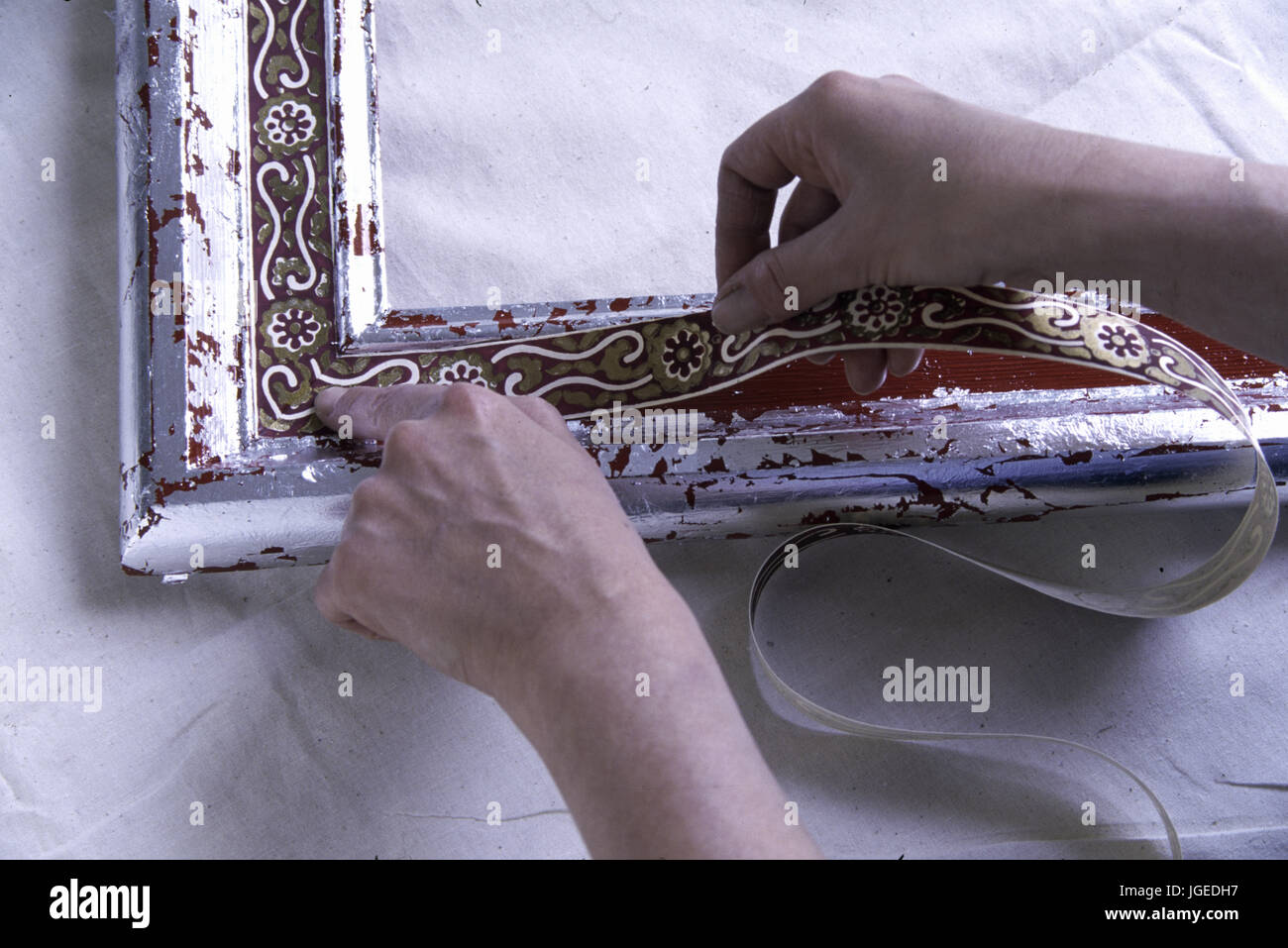 Step x steps on decorating frame. Hands applying decoration to wooden ...