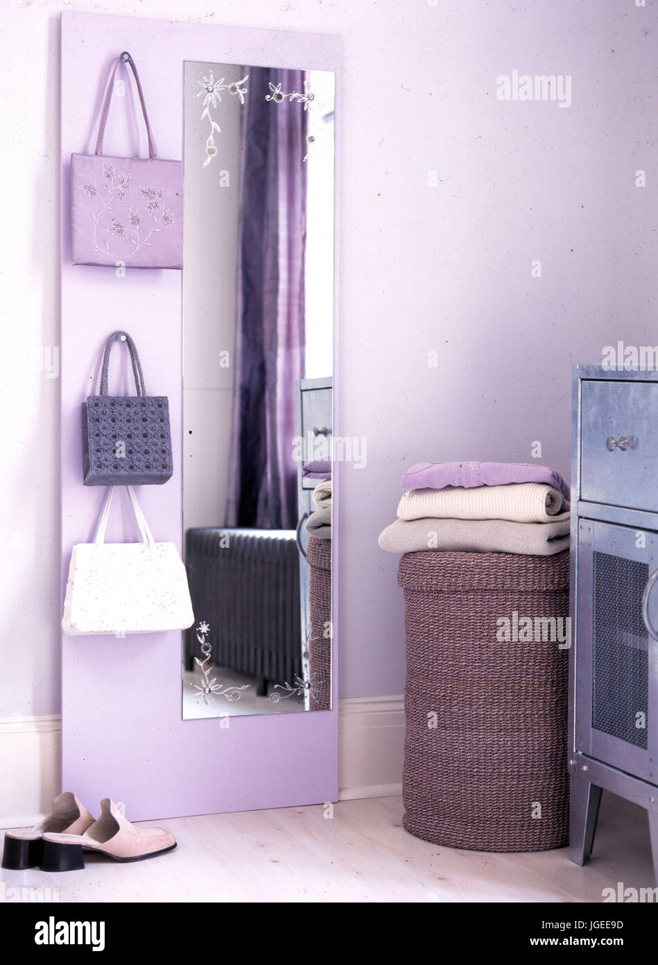 Handbags hanging on wall next to mirror in bathroom Stock Photo - Alamy