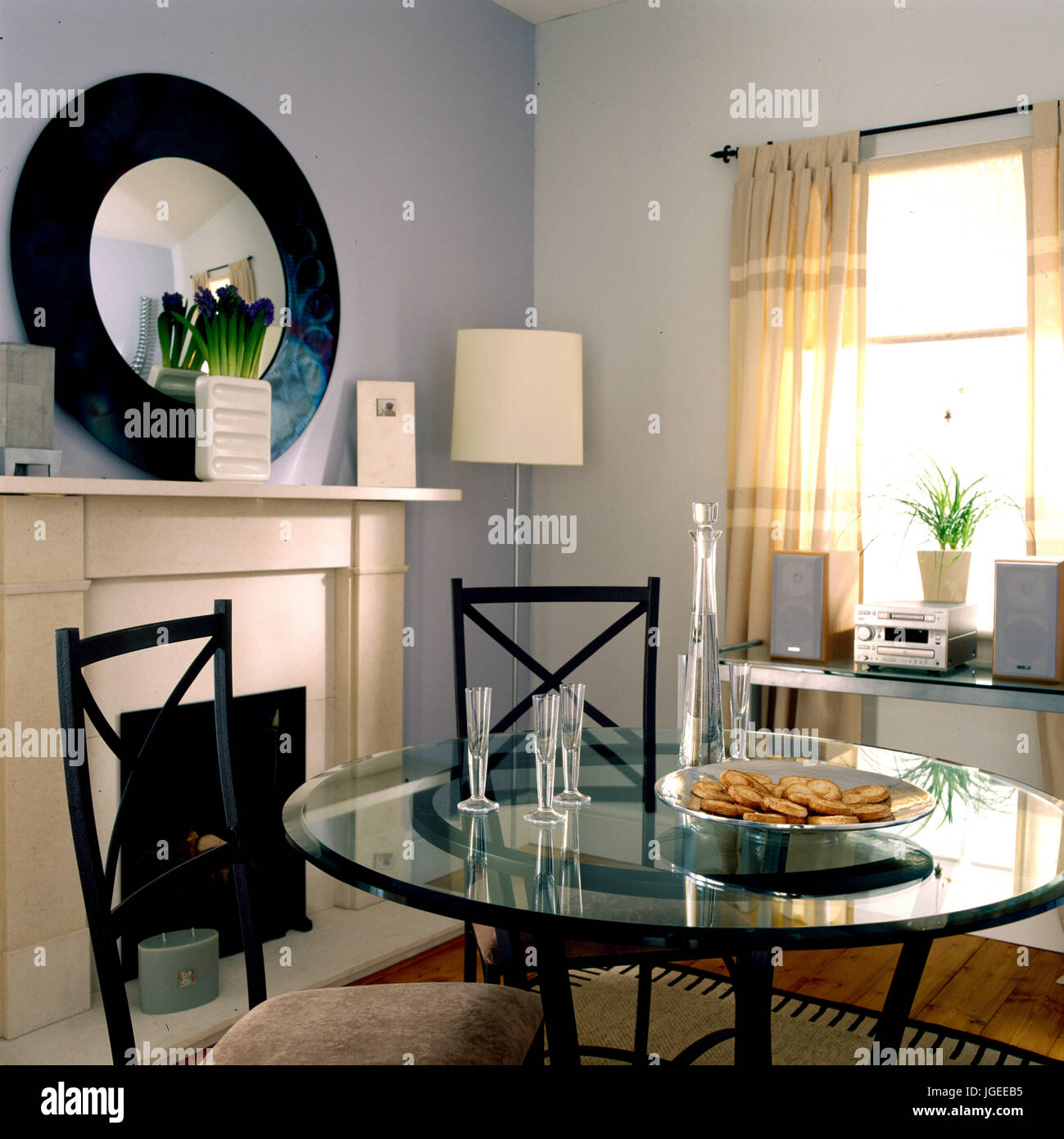 Dining oom in small flat with round glass table Stock Photo - Alamy